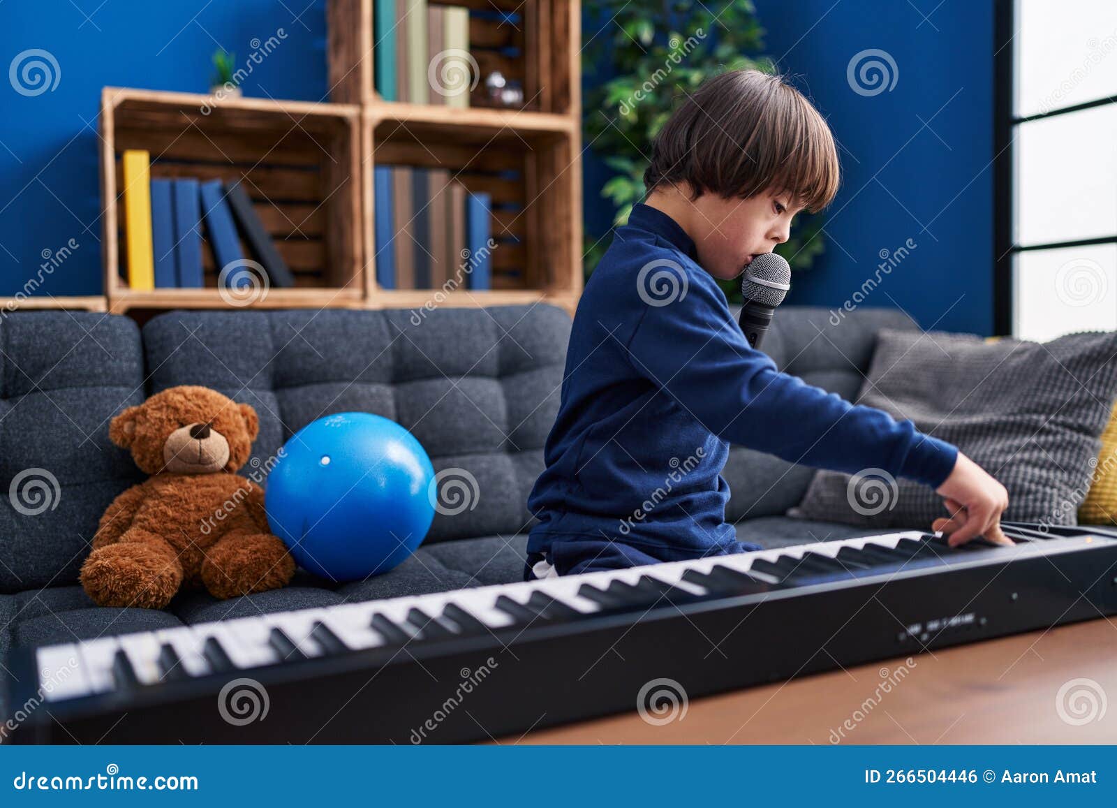 Down Syndrome Kid Singing Song Sitting on Sofa at Home Stock Photo ...