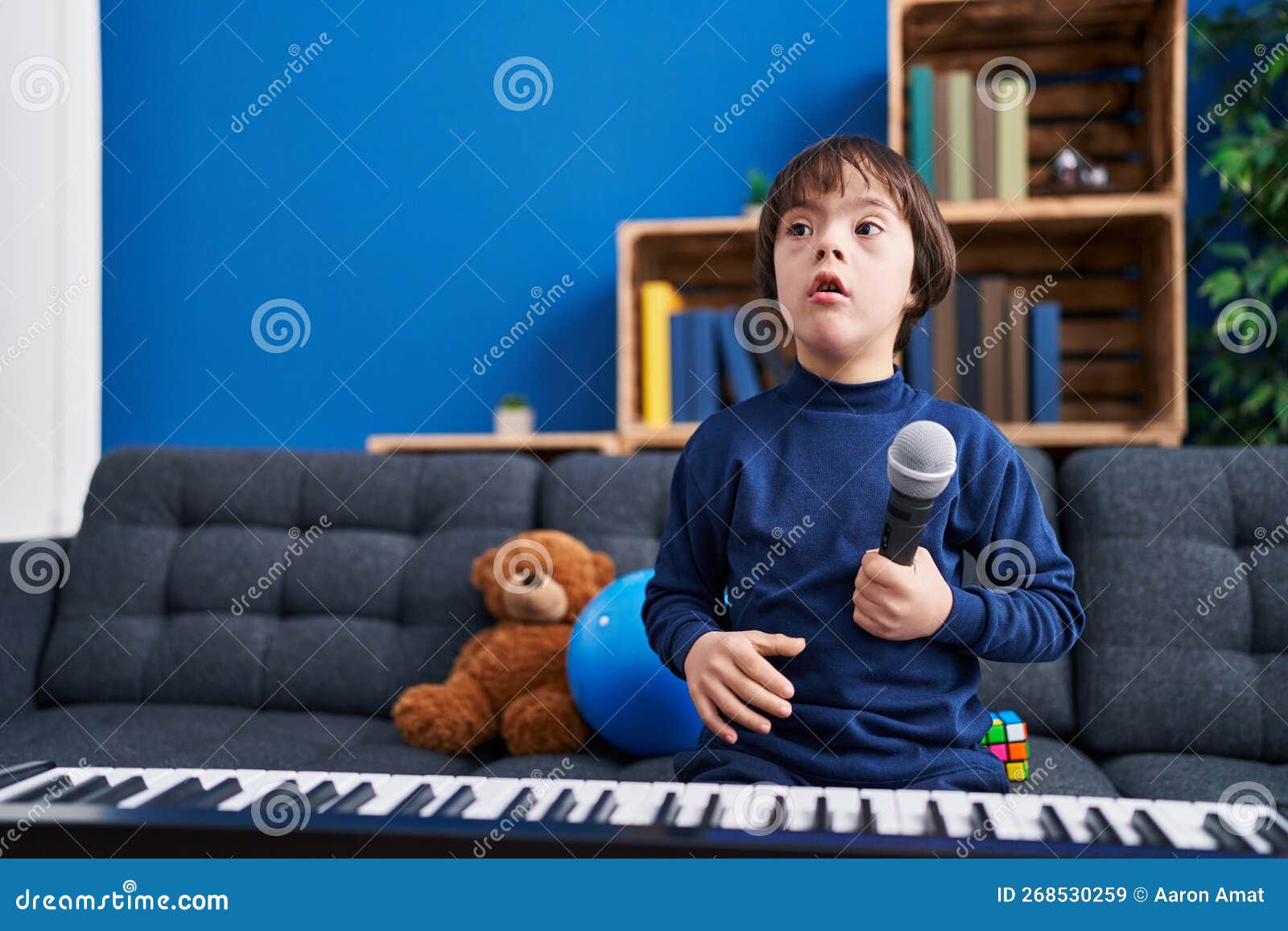 Down Syndrome Kid Singing Song Sitting on Sofa at Home Stock Image ...