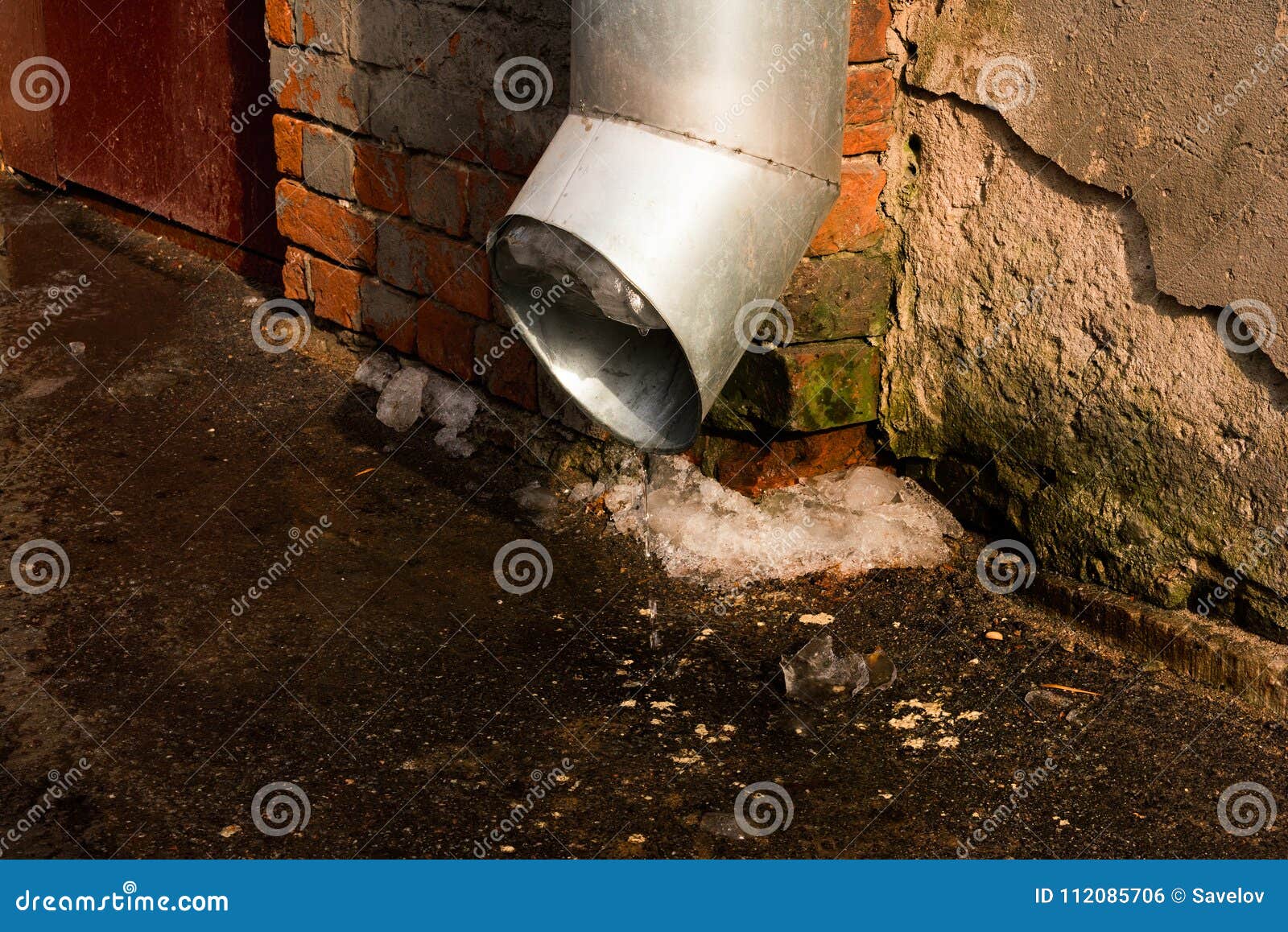 A Drain Pipe with a Piece of Melting Ice in the Spring on the Street ...