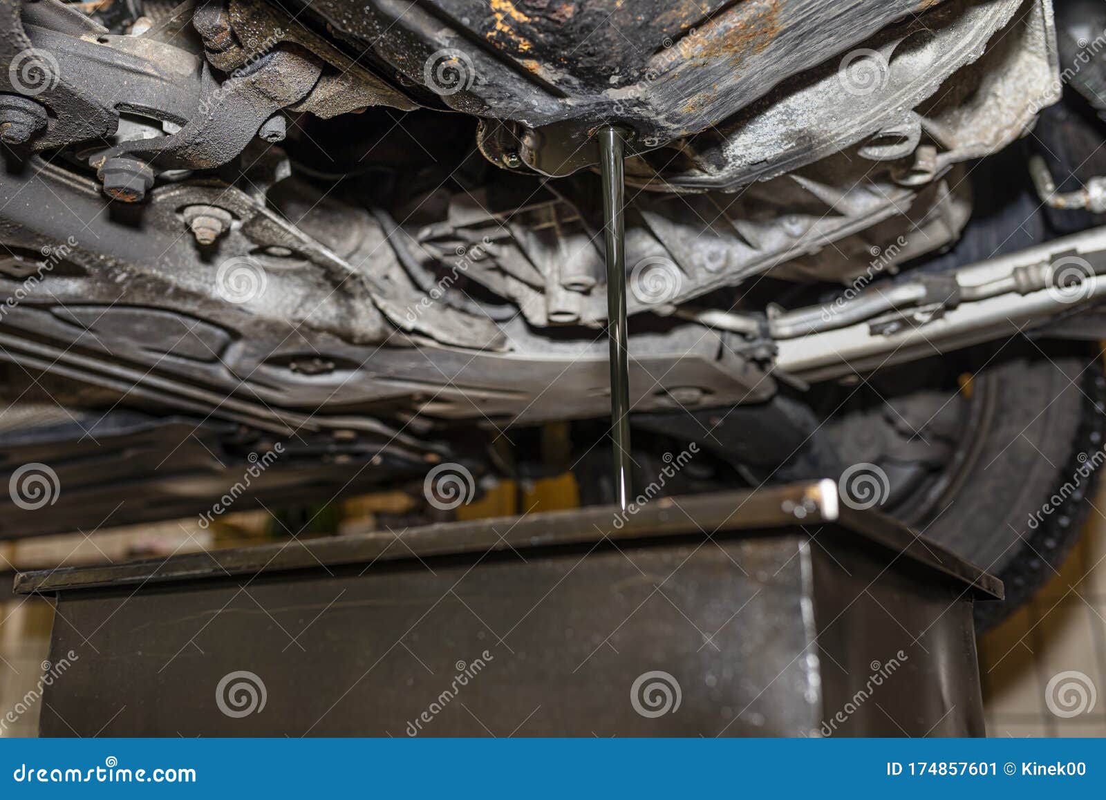 Draining Used Diesel Engine Oil from an Oil Pan into a Metal Container ...