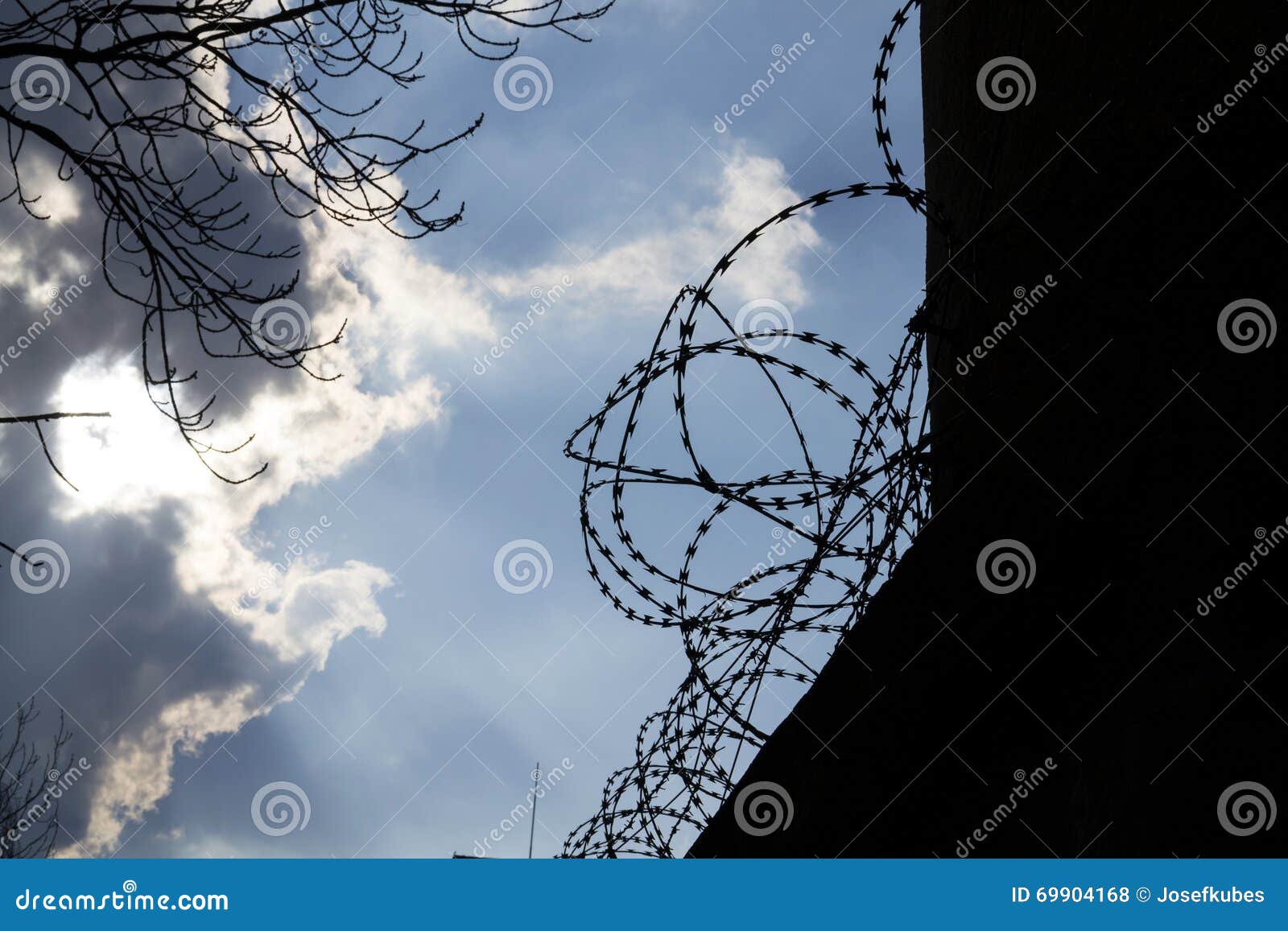 Dramatic Clouds Behind Barbed Wire Fence on Prison Wall Stock Photo ...