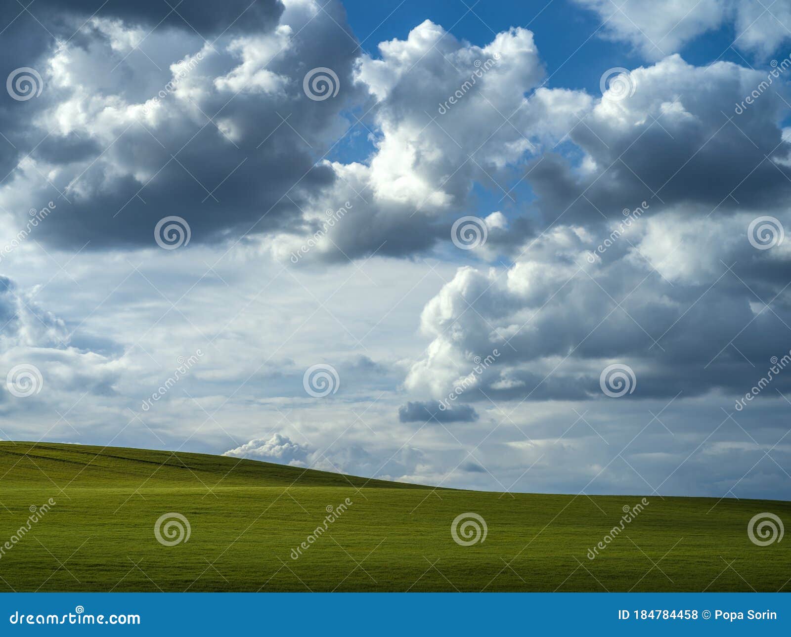 Dramatic Clouds Over a Green Field Stock Photo - Image of blue ...