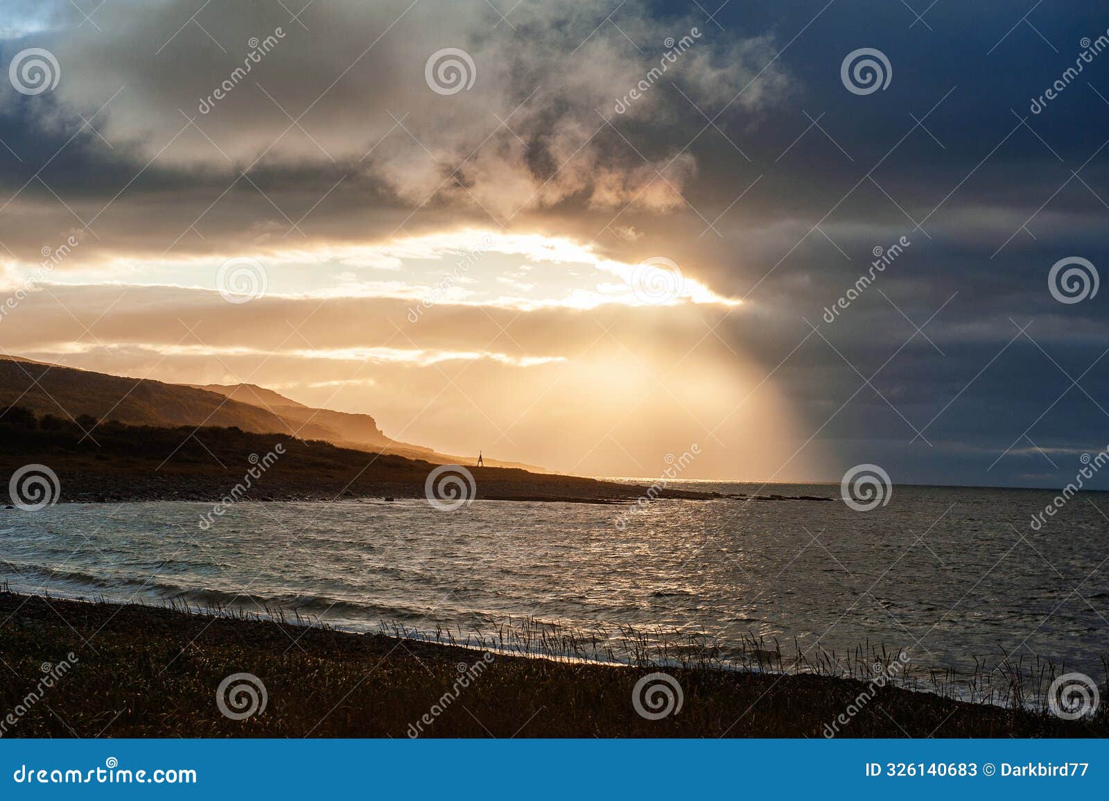 Dramatic Coastal Sunset with Sun Rays through Dark Clouds, Casting ...