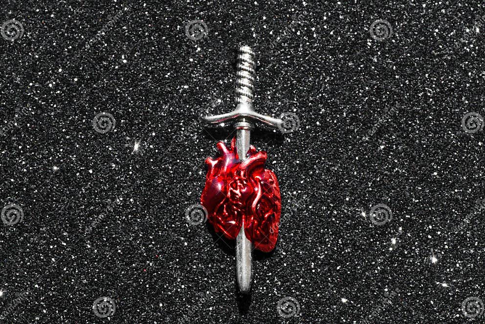 Dramatic Heart and Sword Composition on Glittering Black Surface Stock ...