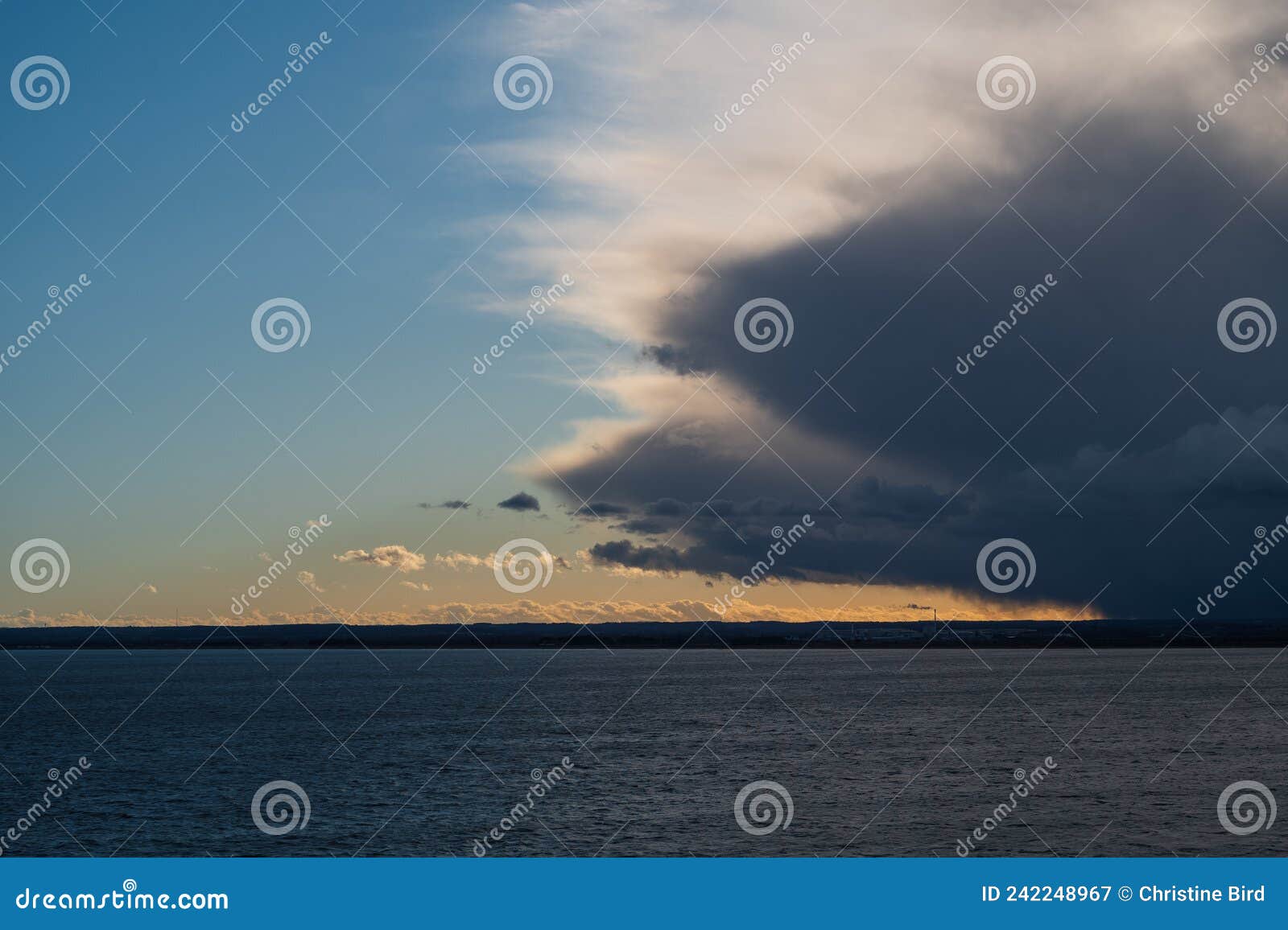 A Dramatic Image of a Rain Cloud on the Horizon Above the Sea and a ...