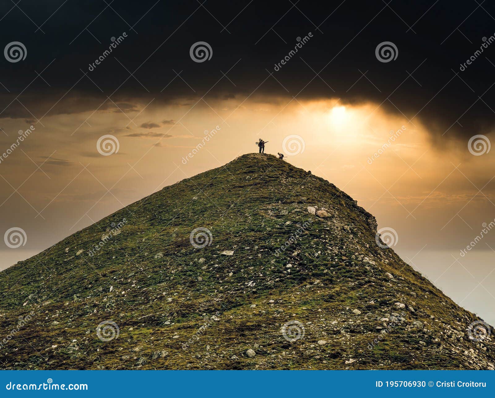 Dramatic Landscape with Three Hikers Reaching the Top of the Mountain ...