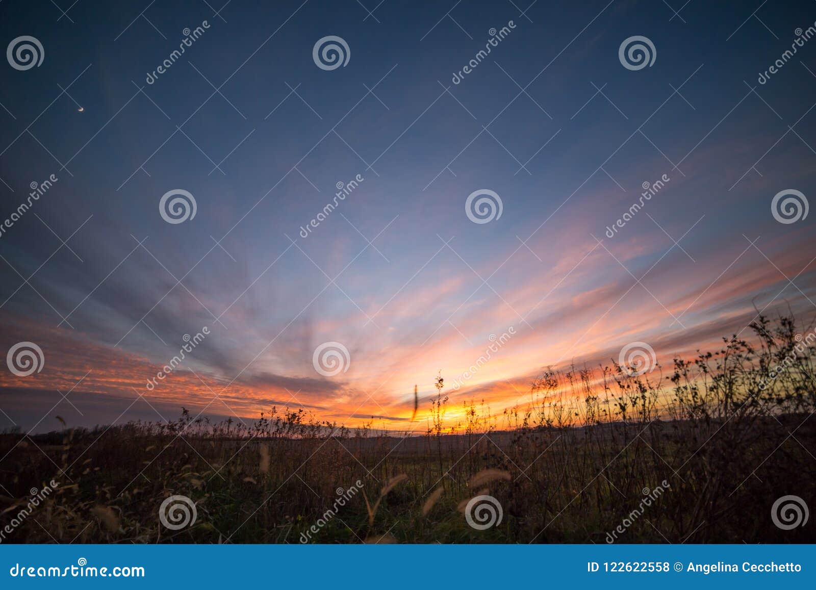 Dramatic Partially Cloudy Crimson Sunset Sky with Moon Crescent Stock ...