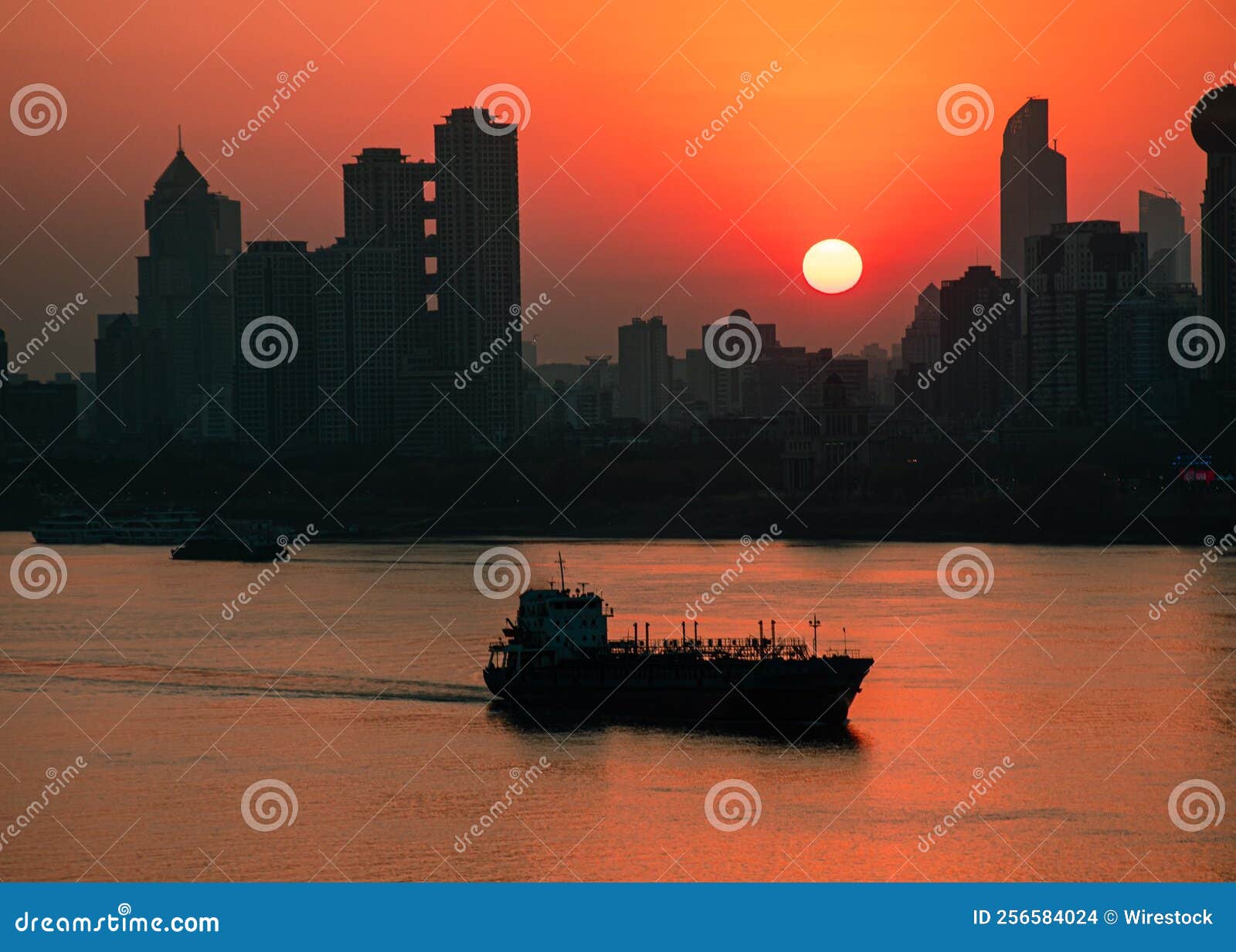 Dramatic Red Sunset Over the Silhouette of a City at the Waterfront ...