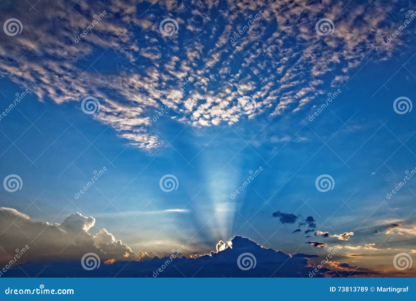 Sunbeams from Below Shine Upwards into a Clouded Sky at Sunset Stock ...