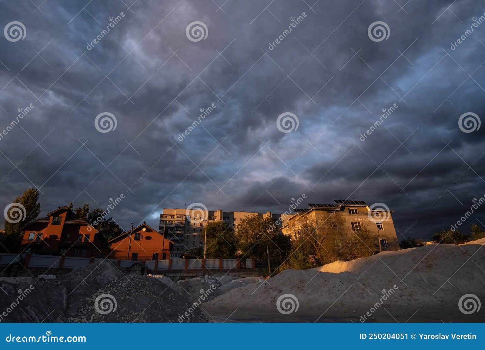 Dramatic Storm Clouds Over the Rooftops at Summer Sunset Stock Image ...