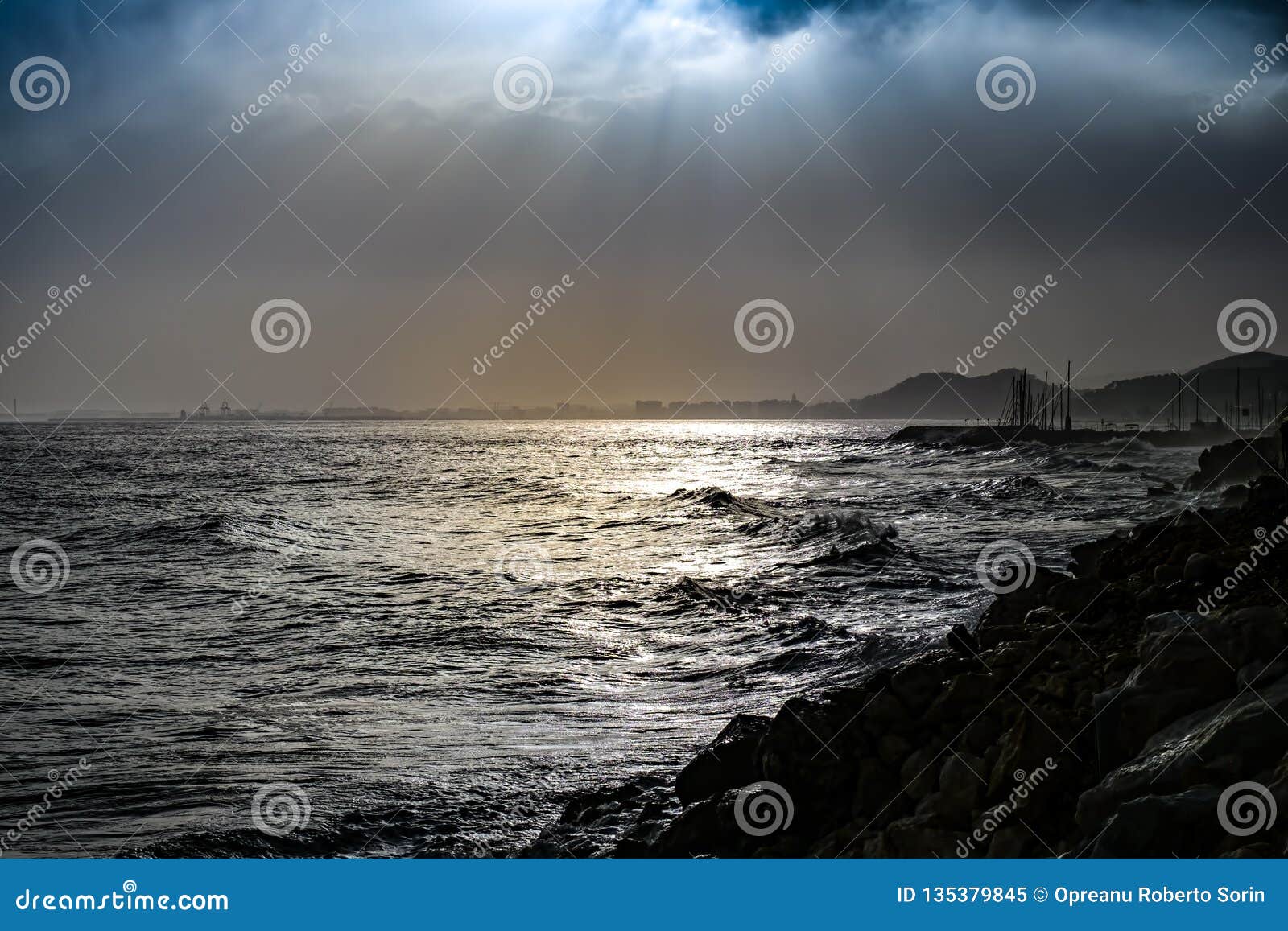 Dramatic Sun Rays through a Cloudy Dark Sky Over the Sea Stock Image ...