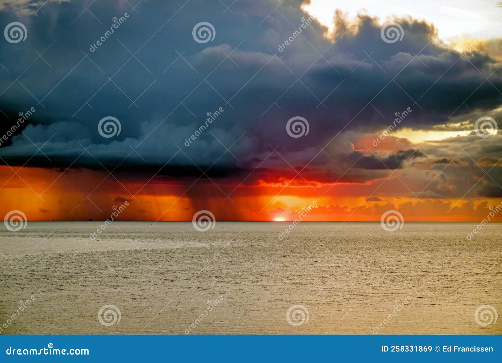 A Disappearing Red Sun and Dark Black Clouds Above a Colorless Sea and ...