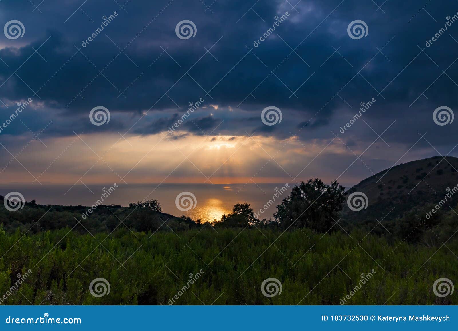 Dramatic Sunset Rays through a Cloudy Dark Sky Over the Ocean Stock ...