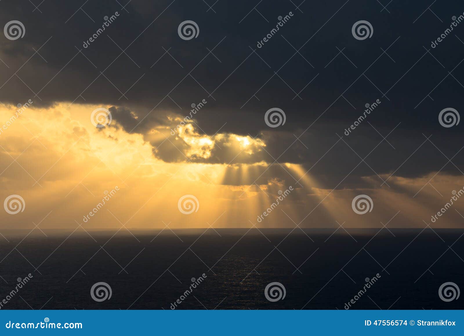 Dramatic Sunset Rays through a Cloudy Dark Sky Over the Ocean Stock ...