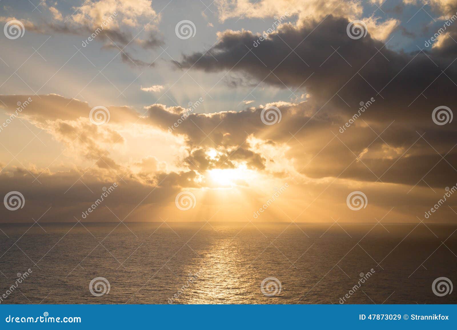 Dramatic Sunset Rays through a Cloudy Dark Sky Over the Ocean Stock ...