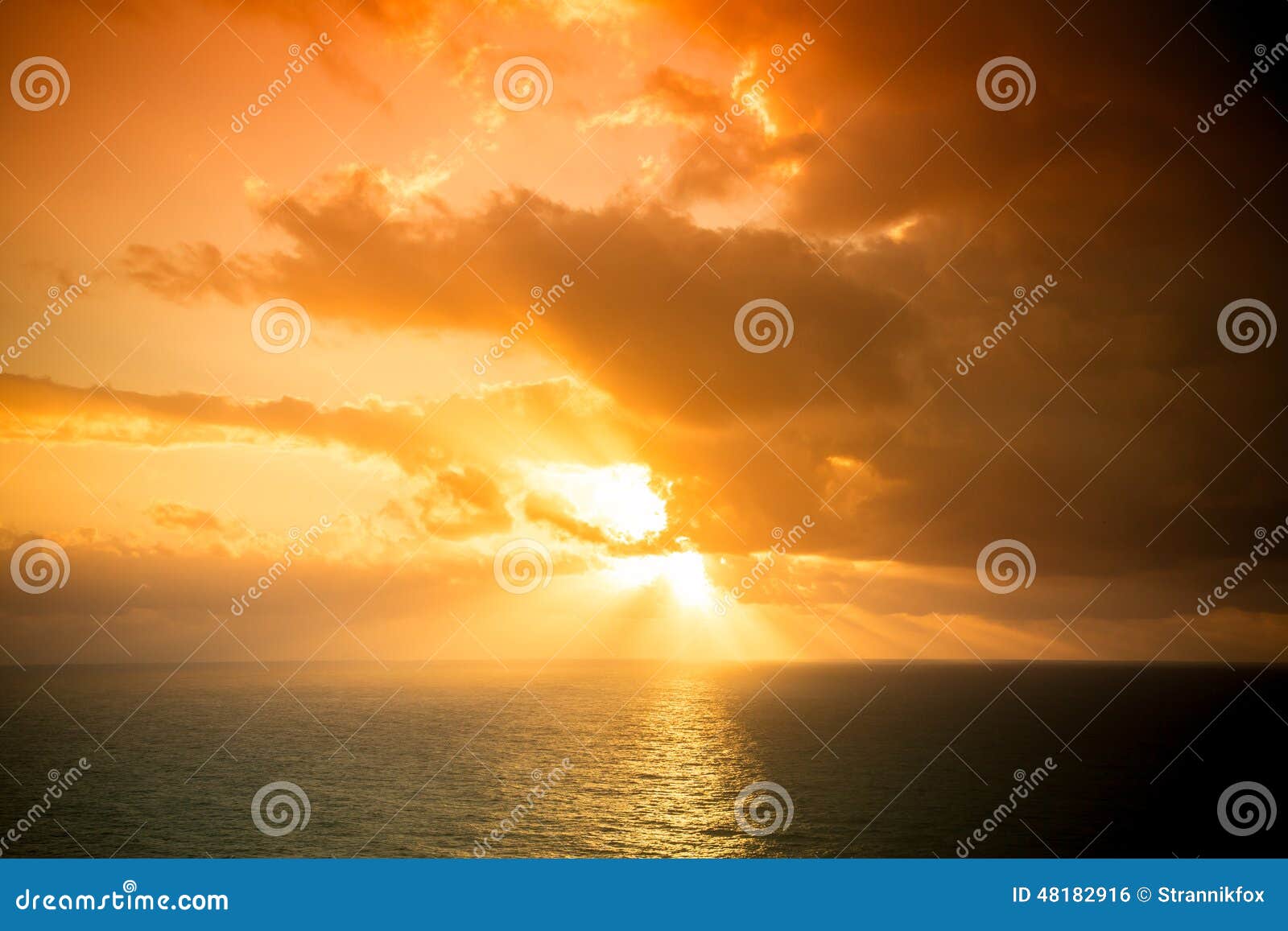 Dramatic Sunset Rays through a Cloudy Dark Sky Over the Ocean. T Stock ...