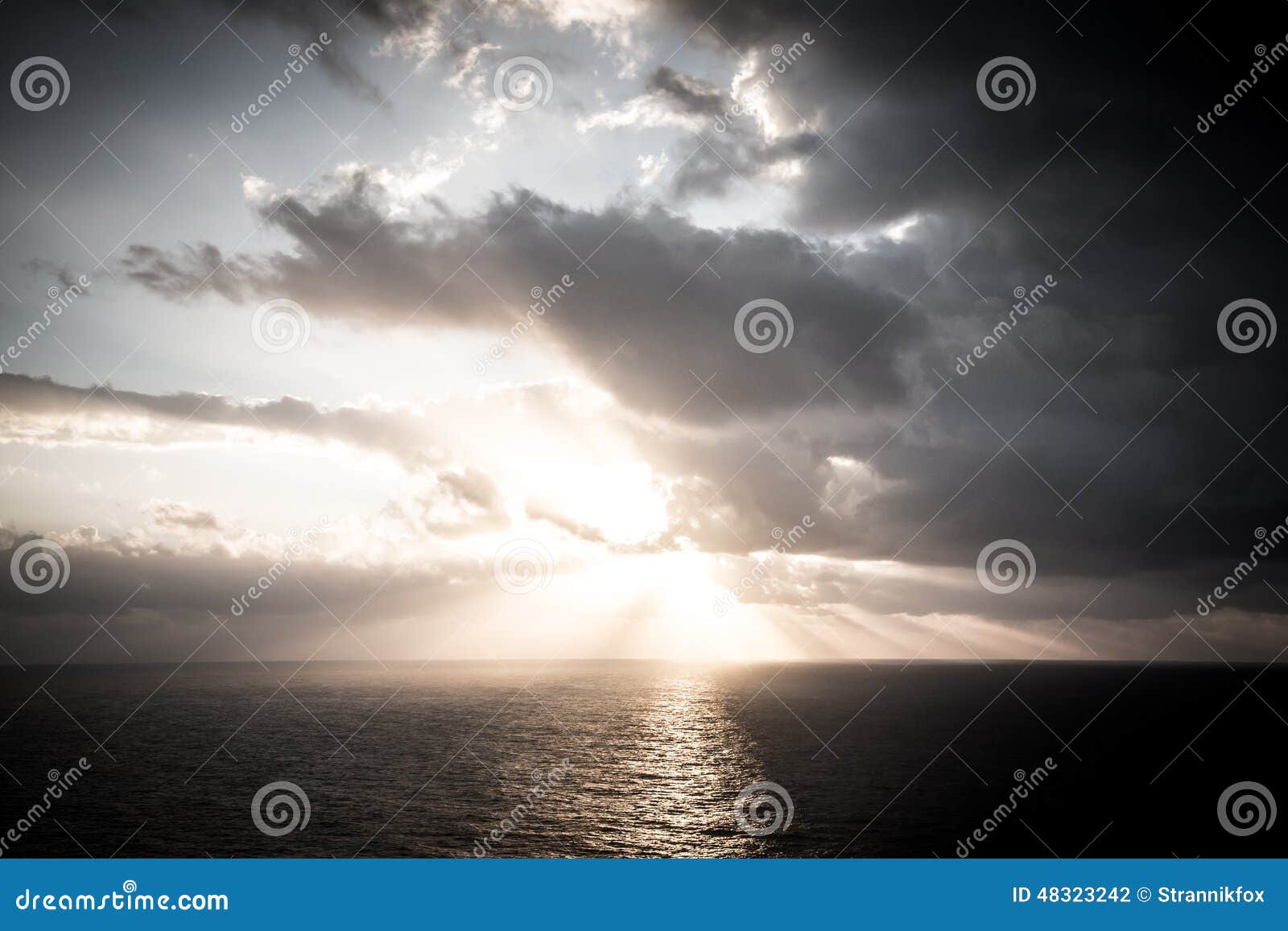Dramatic Sunset Rays through a Cloudy Dark Sky Over the Ocean Stock ...