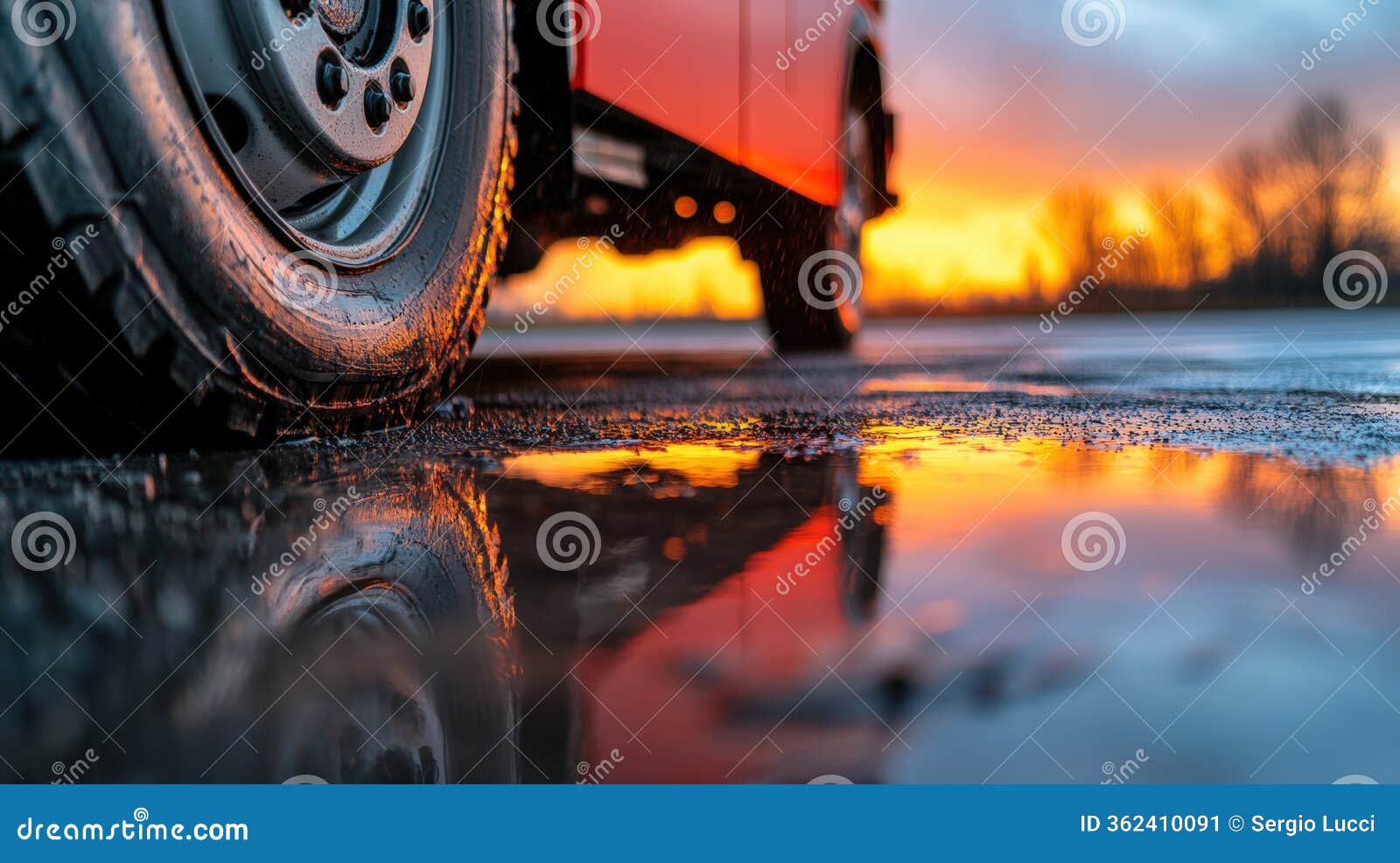 Dramatic Sunset Reflection on Wet Pavement with Vehicle Wheel in ...