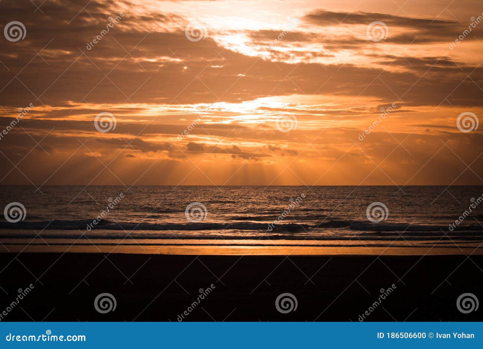 Dramatic Sunset Scene with Rays of Sun Light and Clouds Over the Sea ...