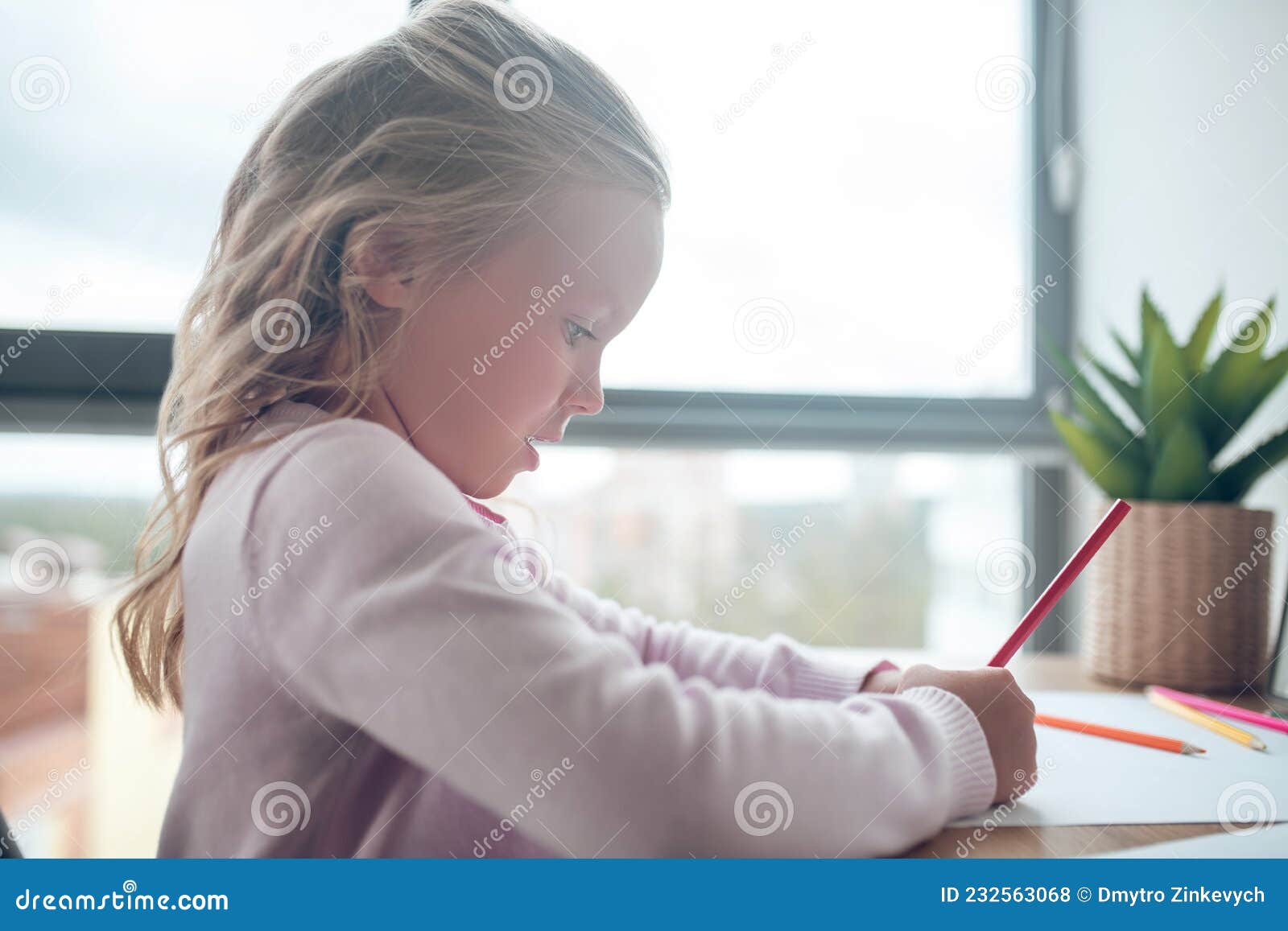 A Cute Girl Sitting at the Table and Drawing Stock Photo - Image of ...