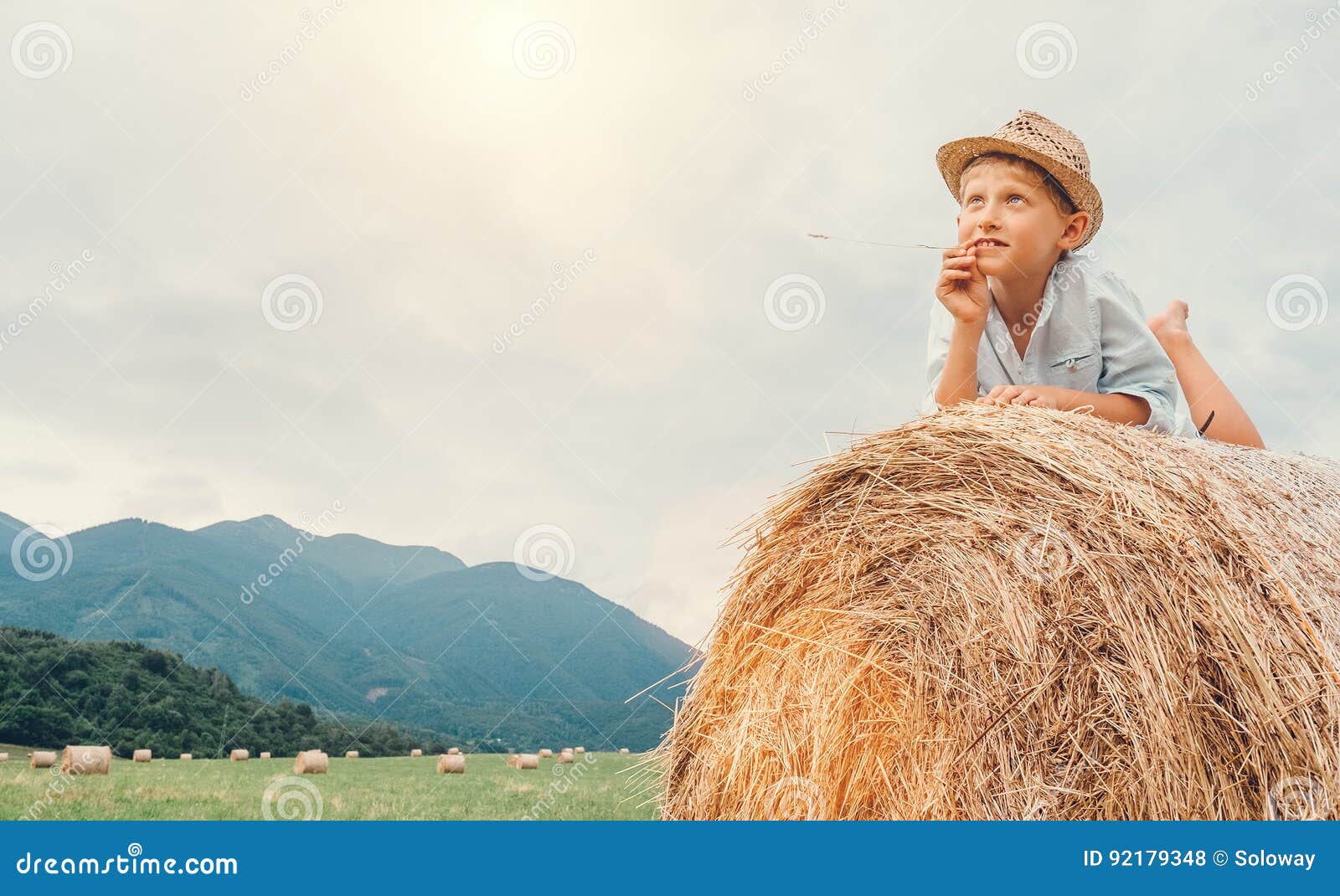 Dreaming Boy in Straw Hat Lies on Roll Haystack Stock Photo - Image of ...