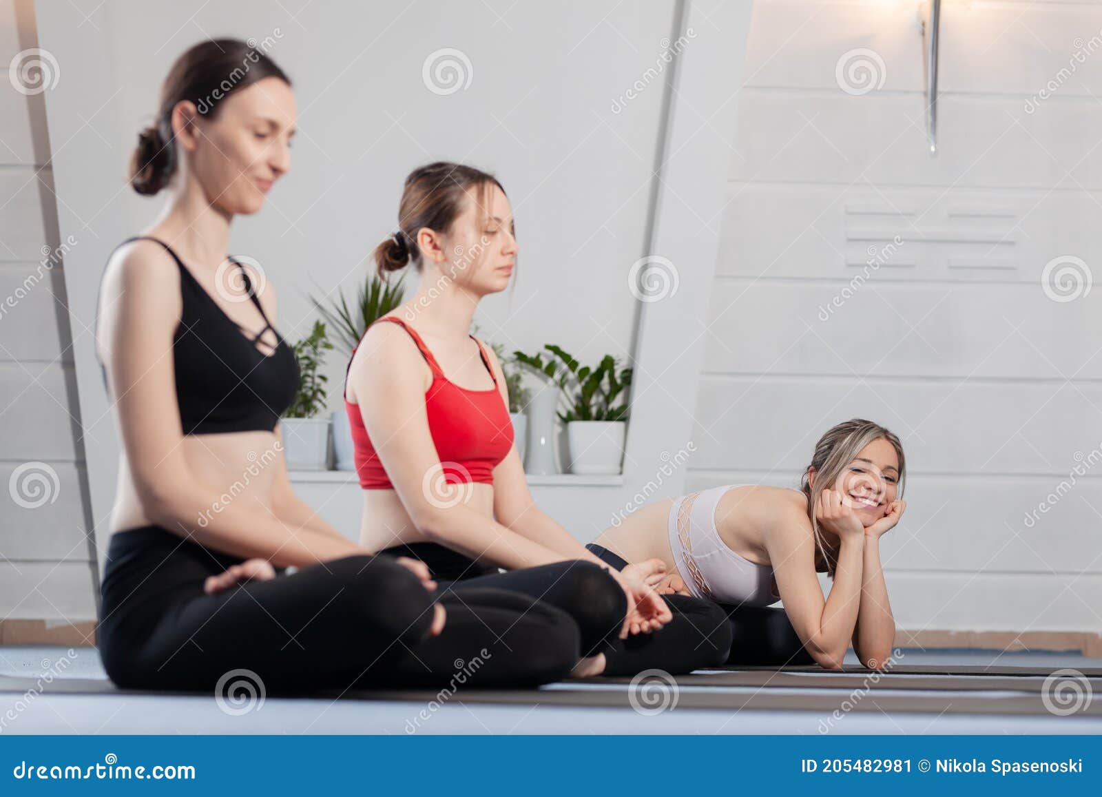 Drei Mädchen, Die Yoga üben. Yogalehrer Mit Ihren Schülern, Die in ... Drei Mädchen, Die Yoga üben. Yogalehrer Mit Ihren Schülern, Die in ...