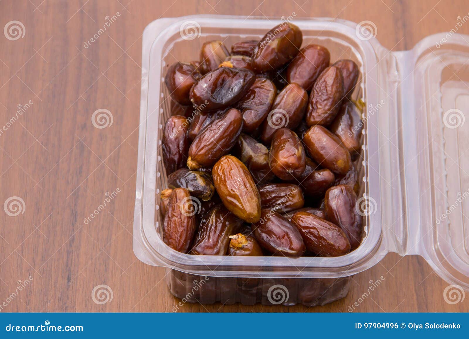 Dried Date Fruits in Plastic Container on Wooden Table Stock Photo ...