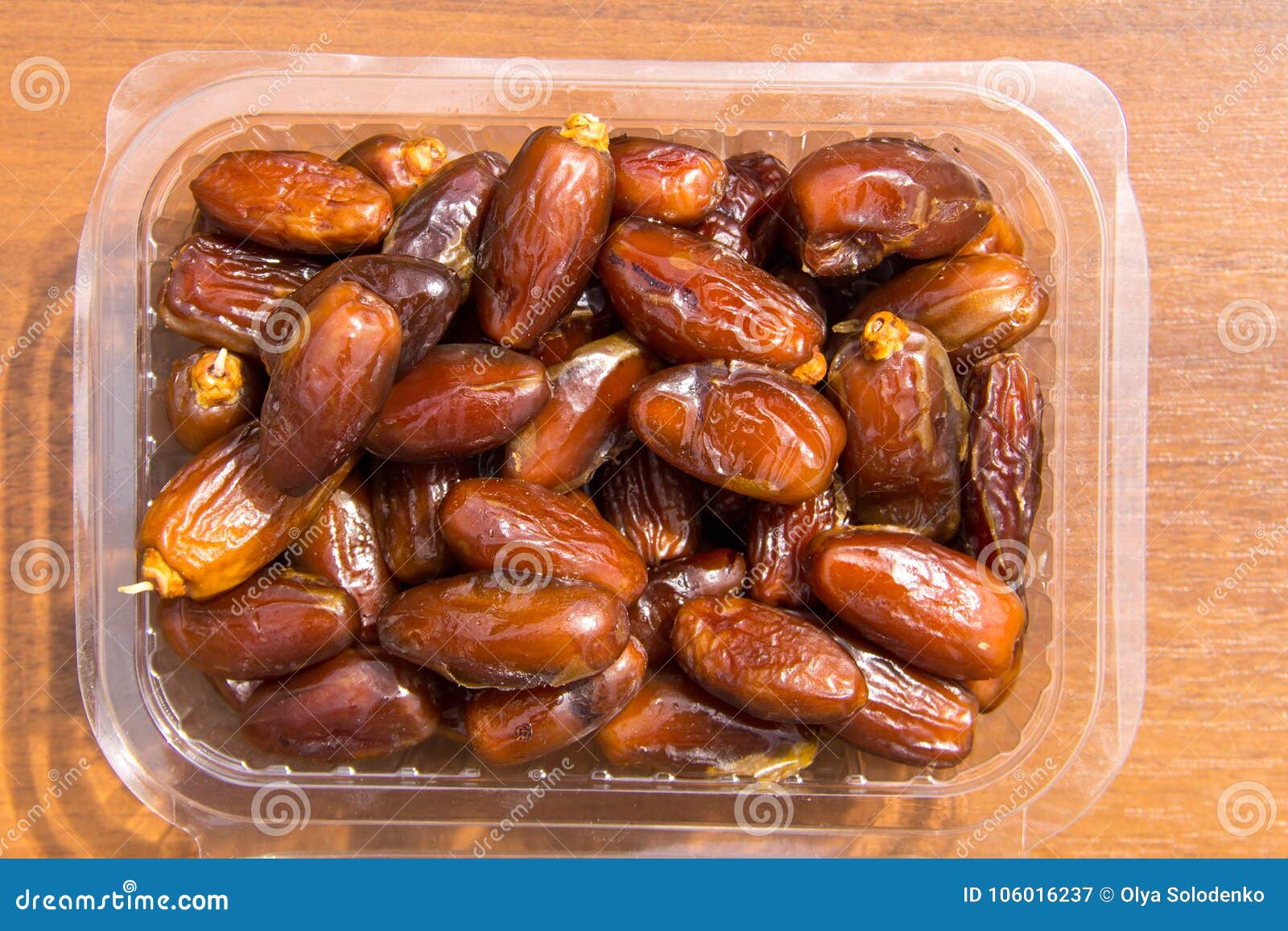 Dried Date Fruits in Plastic Container on Wooden Table Stock Image ...