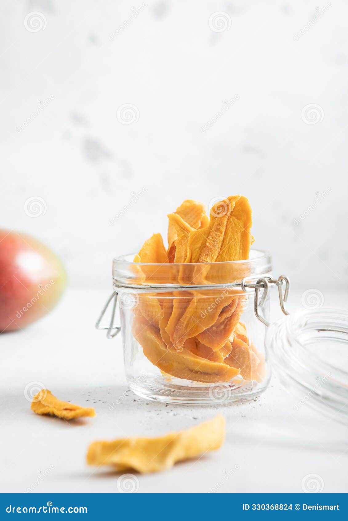 Dried Mango Pieces in Glass Jar and Raw Fruit on Light Background with ...