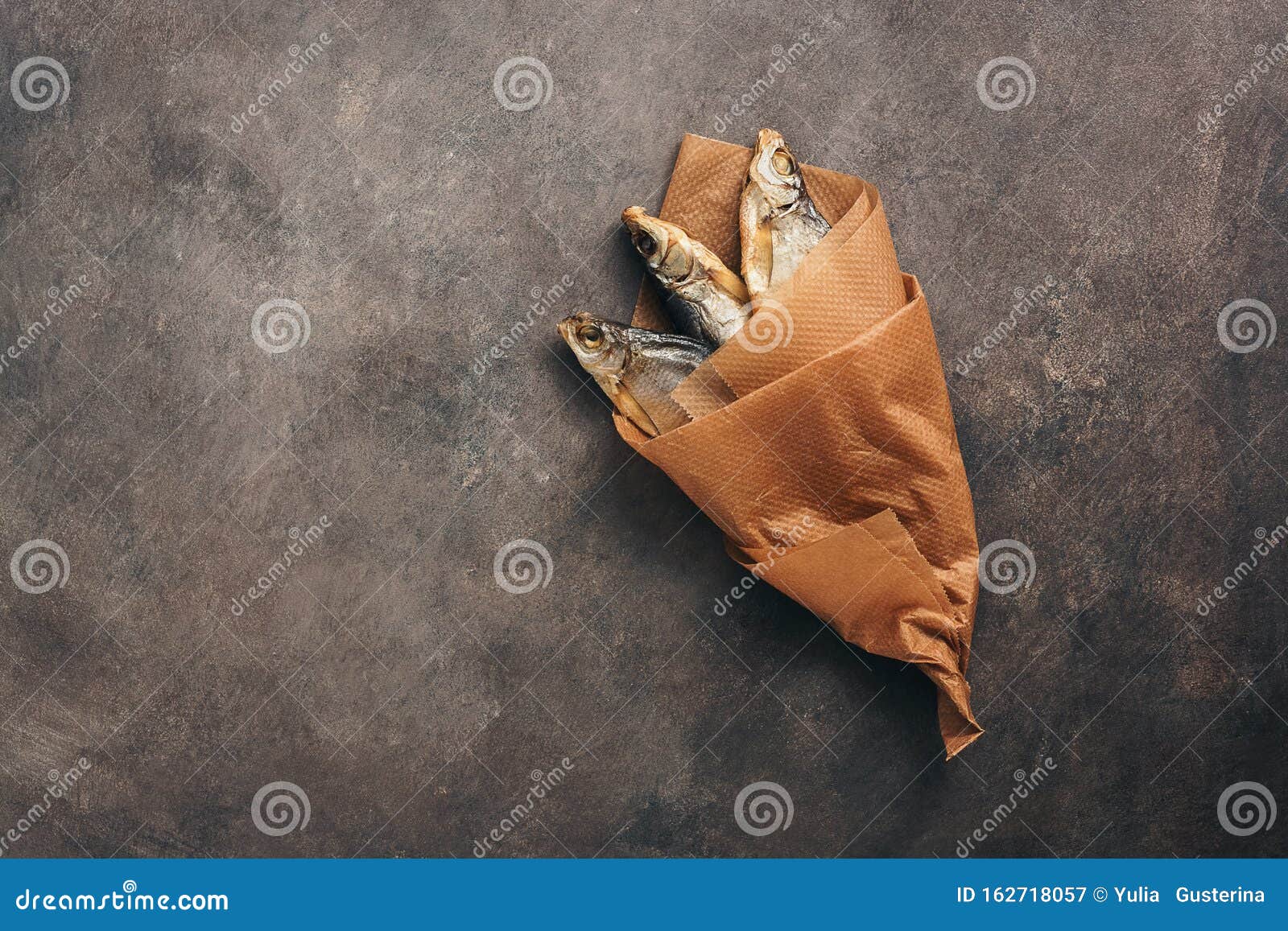 Dried Salted Fish in a Paper Cone on a Dark Brown Rustic Background ...