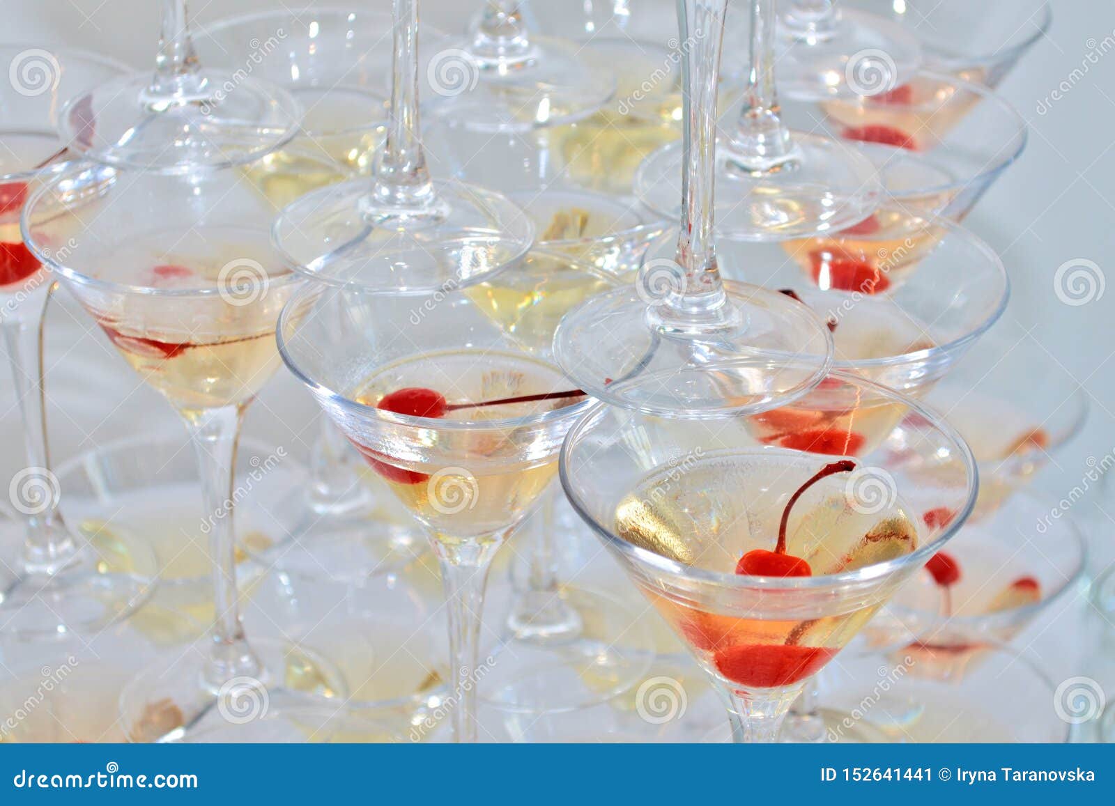 Driehoekige Die Martini-glazen, Met Champagne Met Kersen En Vloeibare ... Driehoekige Die Martini-glazen, Met Champagne Met Kersen En Vloeibare ...