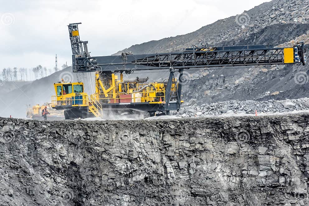 The Drilling Machine Moves Along the Surface of the Quarry Ledge. Stock ...