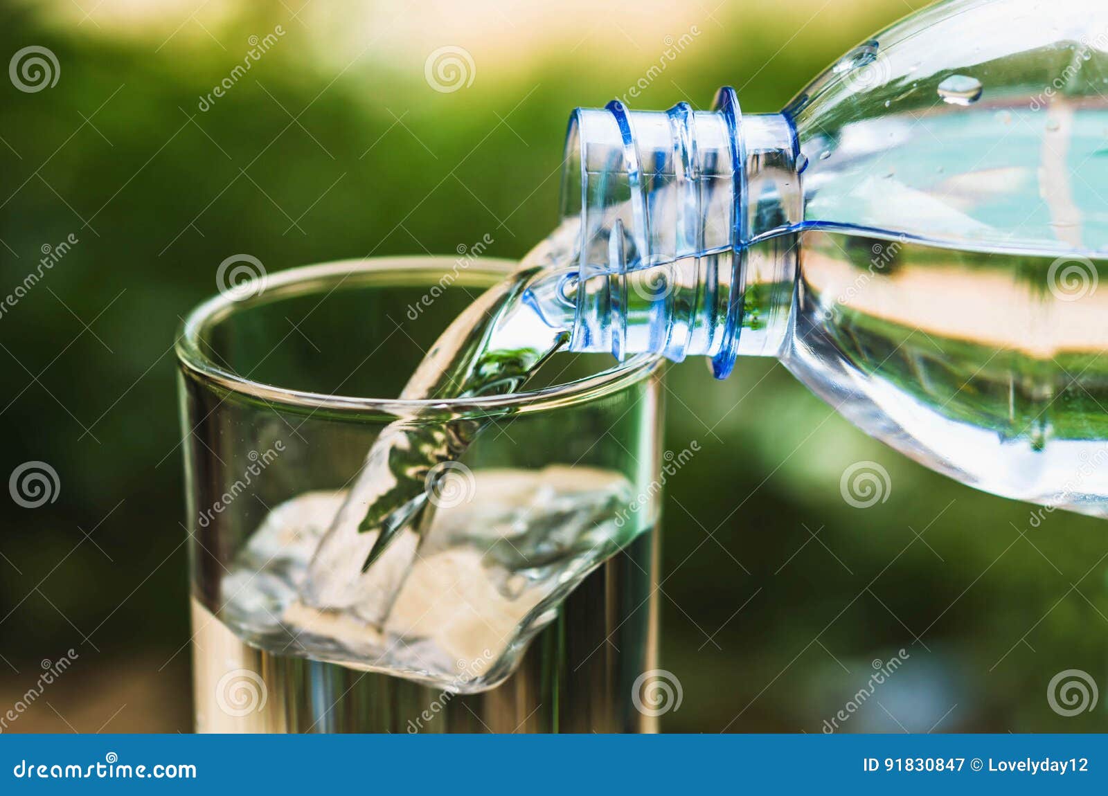 Water Poured Out Of Bottle Into Glass Isolated On White Background ...