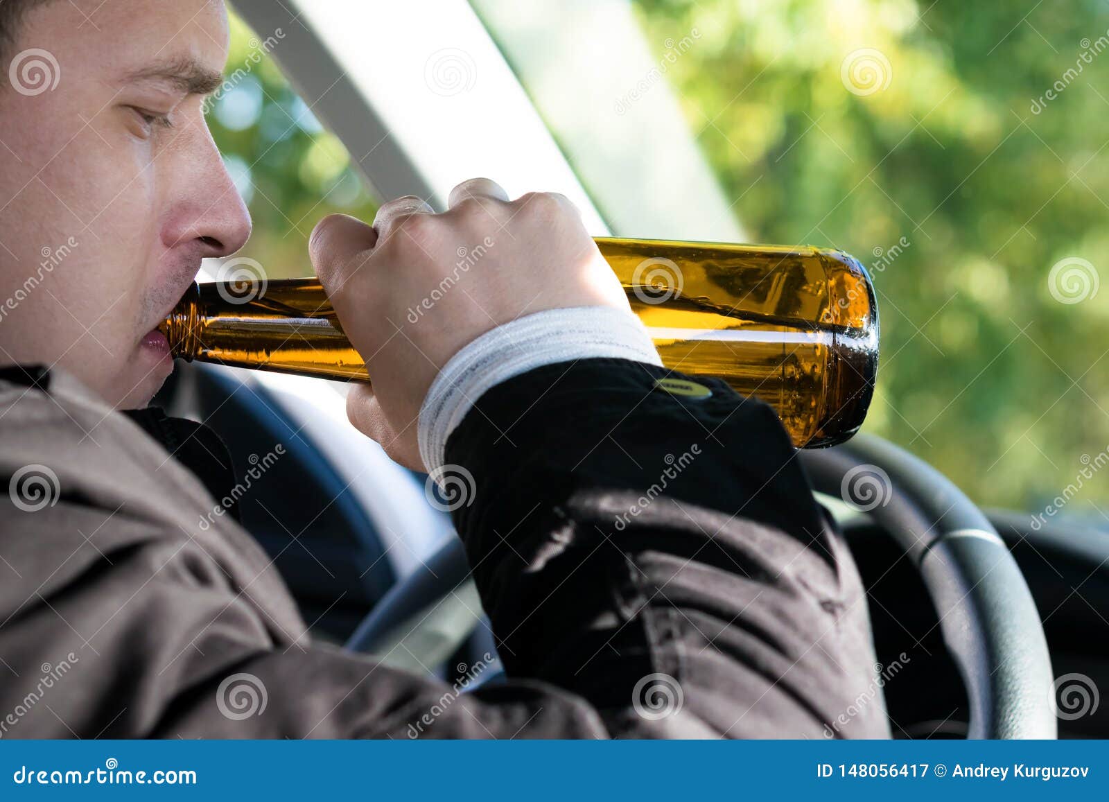 The Driver of the Car Drinks Alcoholic Beverages Behind the Wheel Stock ...