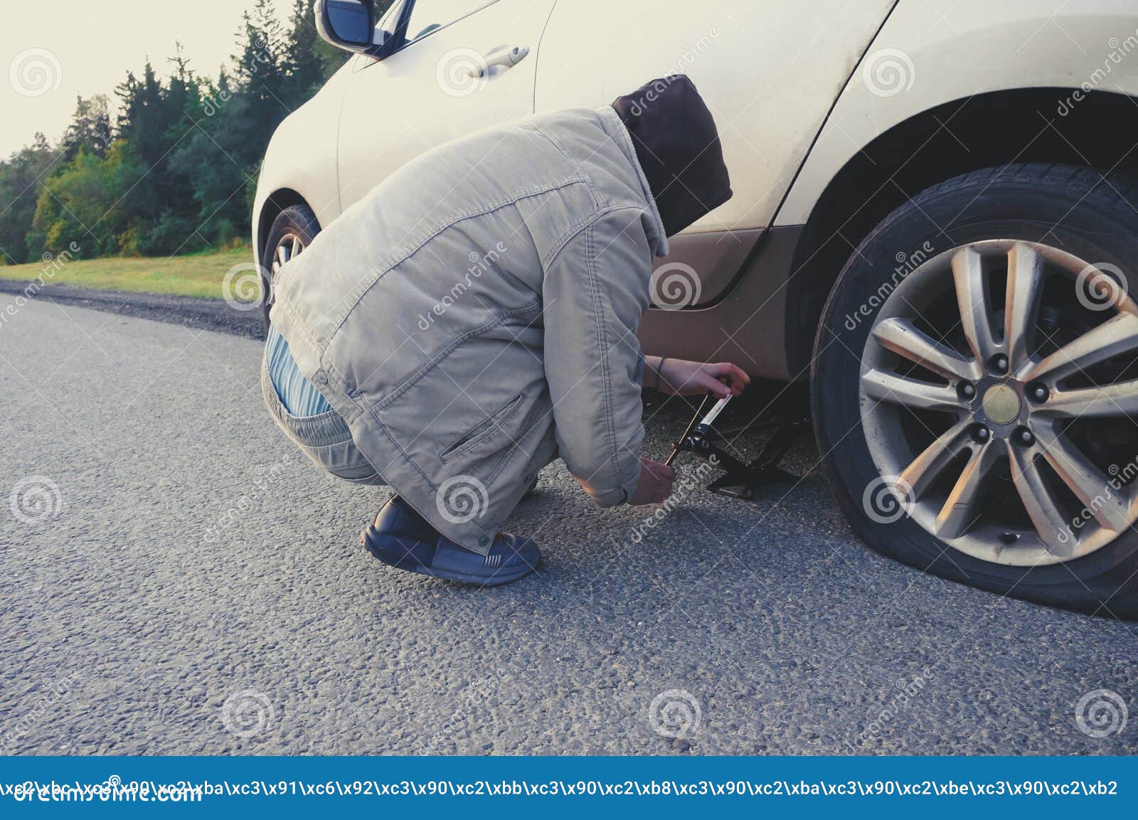 The Driver Independently Changes the Flat Tire and Puts the Spare Tire ...