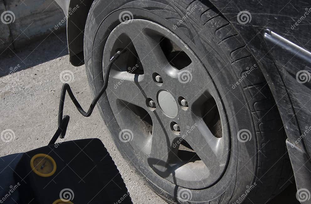 The Driver Pumps Up the Wheel of a Car with the Help of a Compressor ...