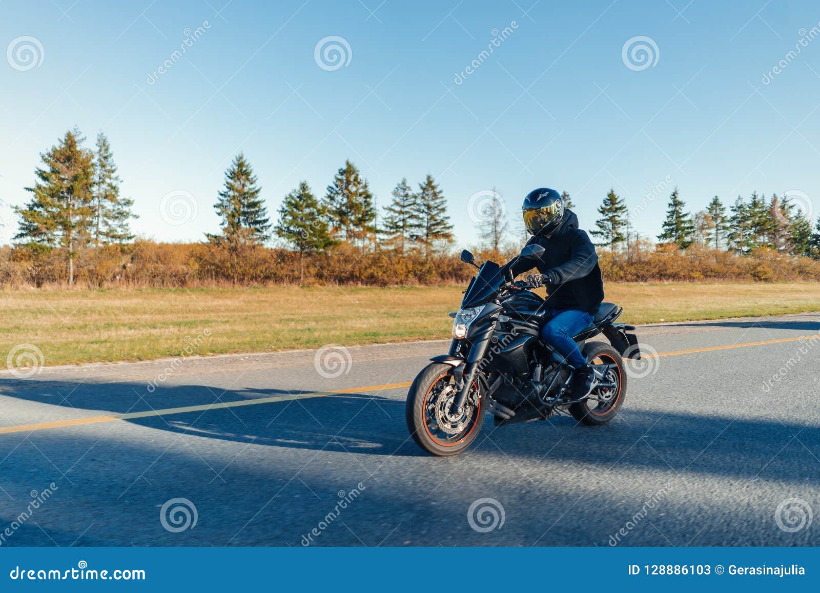 Driver Riding Motorcycle on Empty Road in Beautiful Autumn Forest ...