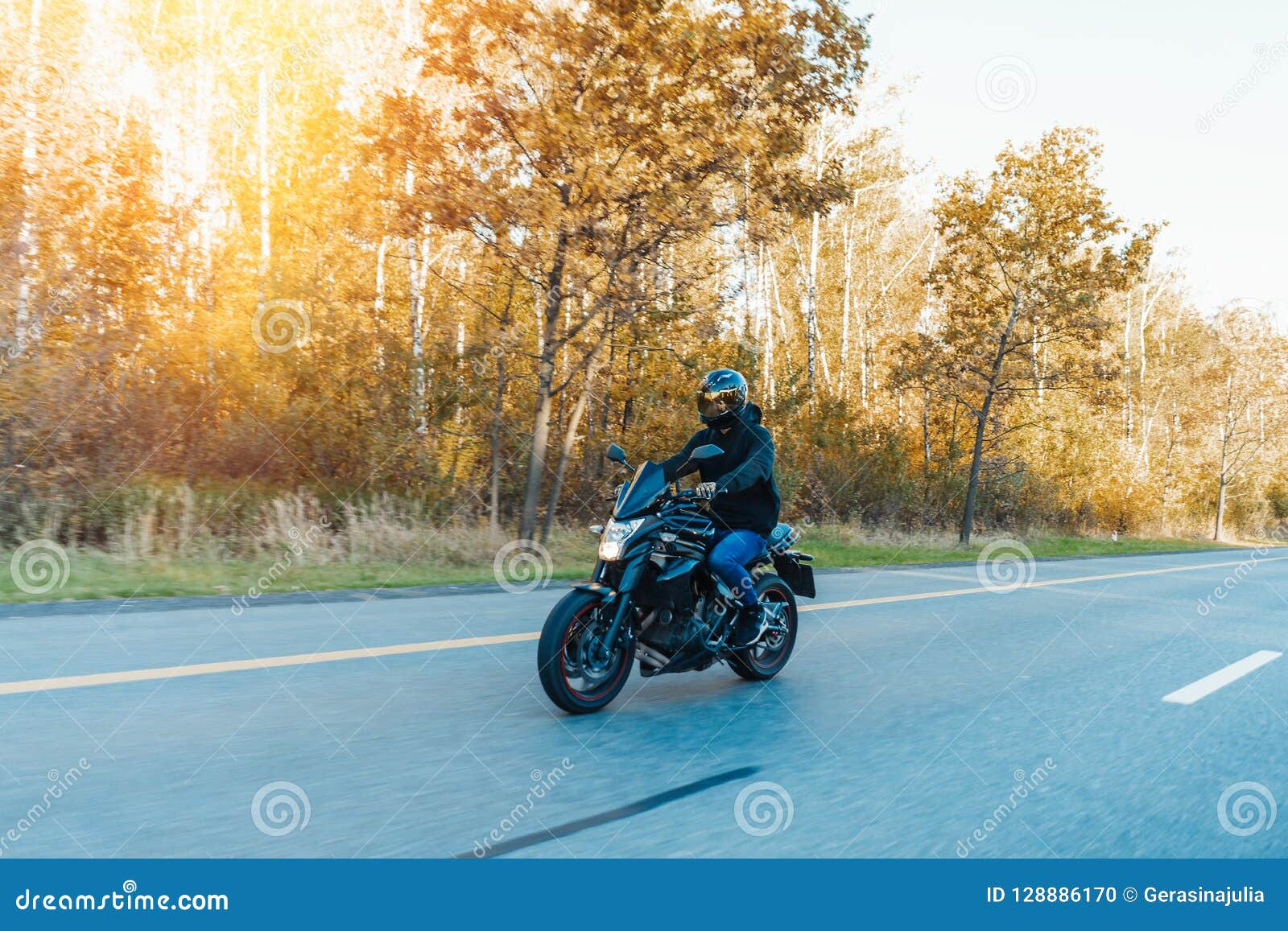 Driver Riding Motorcycle on Empty Road in Beautiful Autumn Forest ...