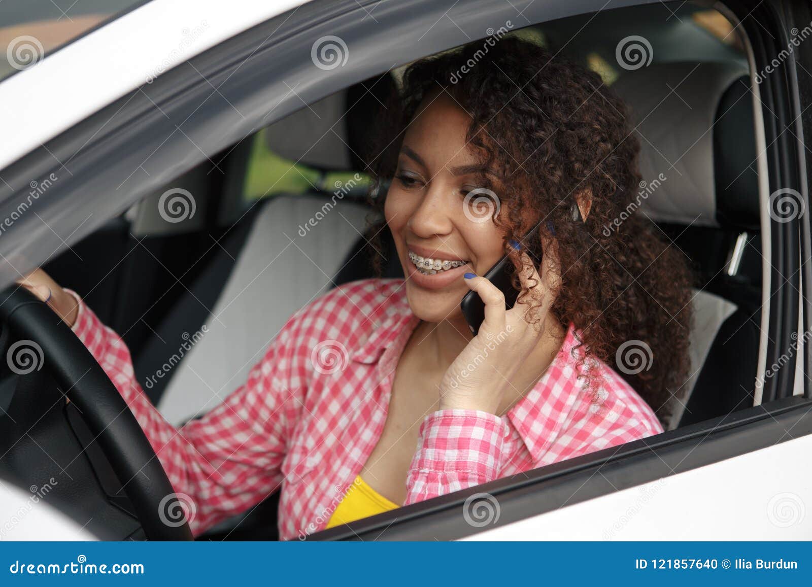 Driver Woman Driving A Car Distracted On The Phone And Looking At Side