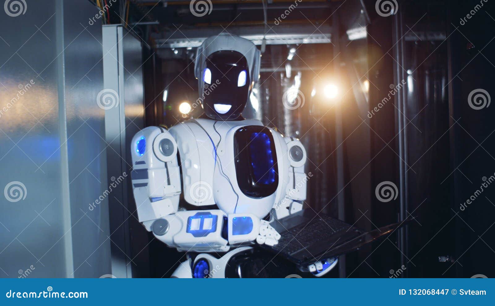 A Robot Works at a Data Center. Droid Stands with a Laptop in Hands in ...