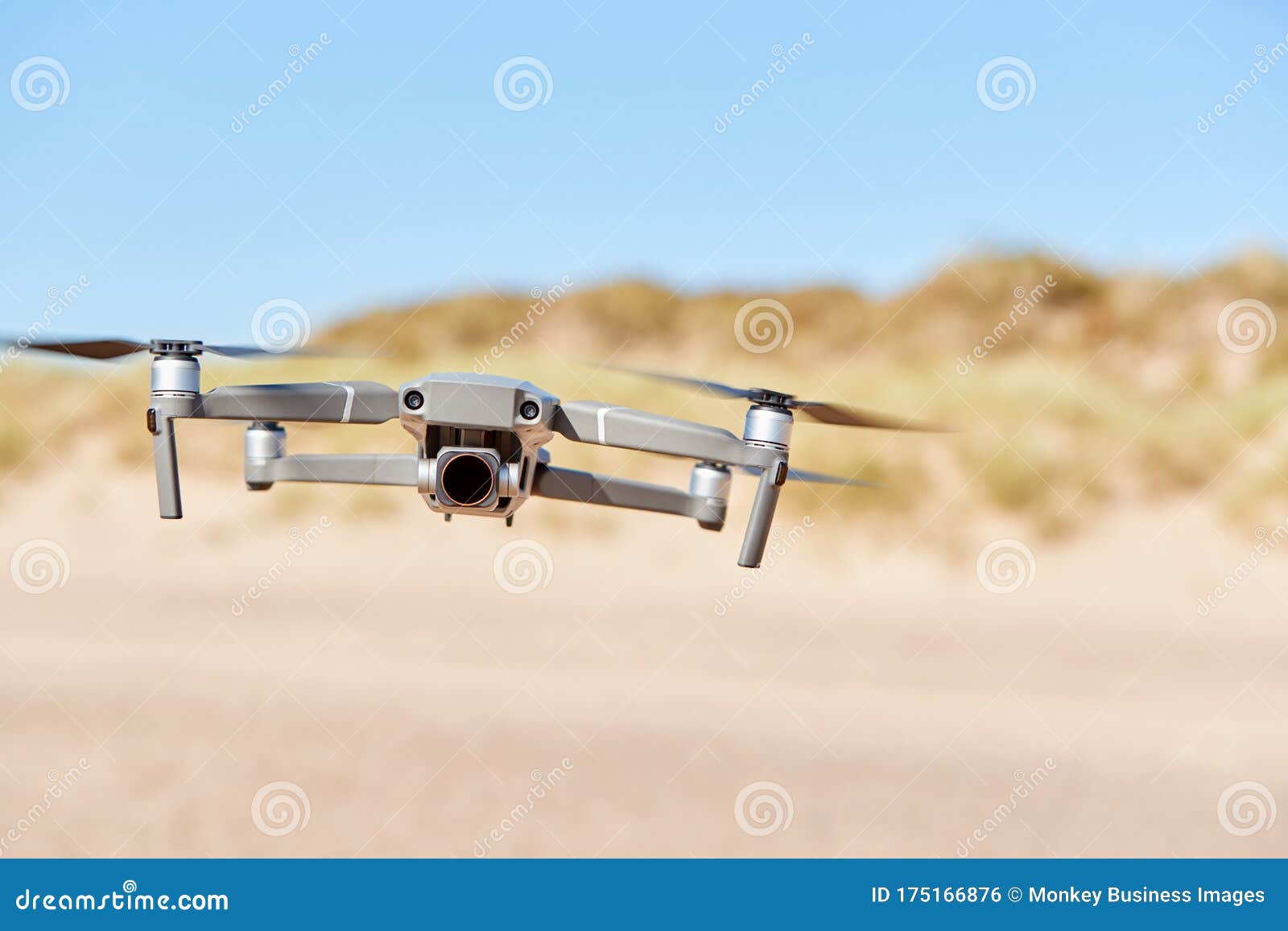 Drone with Camera Flying on Beach with Sand Dunes in Background Stock ...