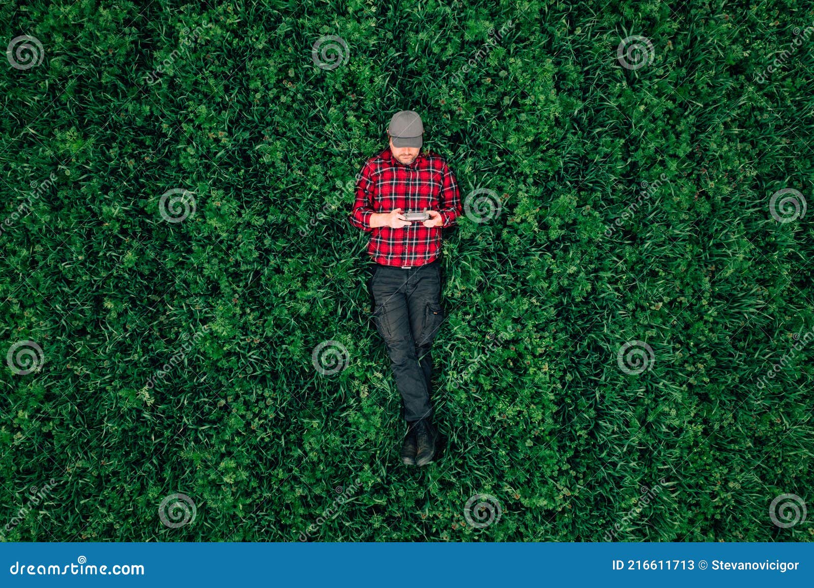 Drone Operator, Top View of Man Lying in Grass Field and Using Drone ...