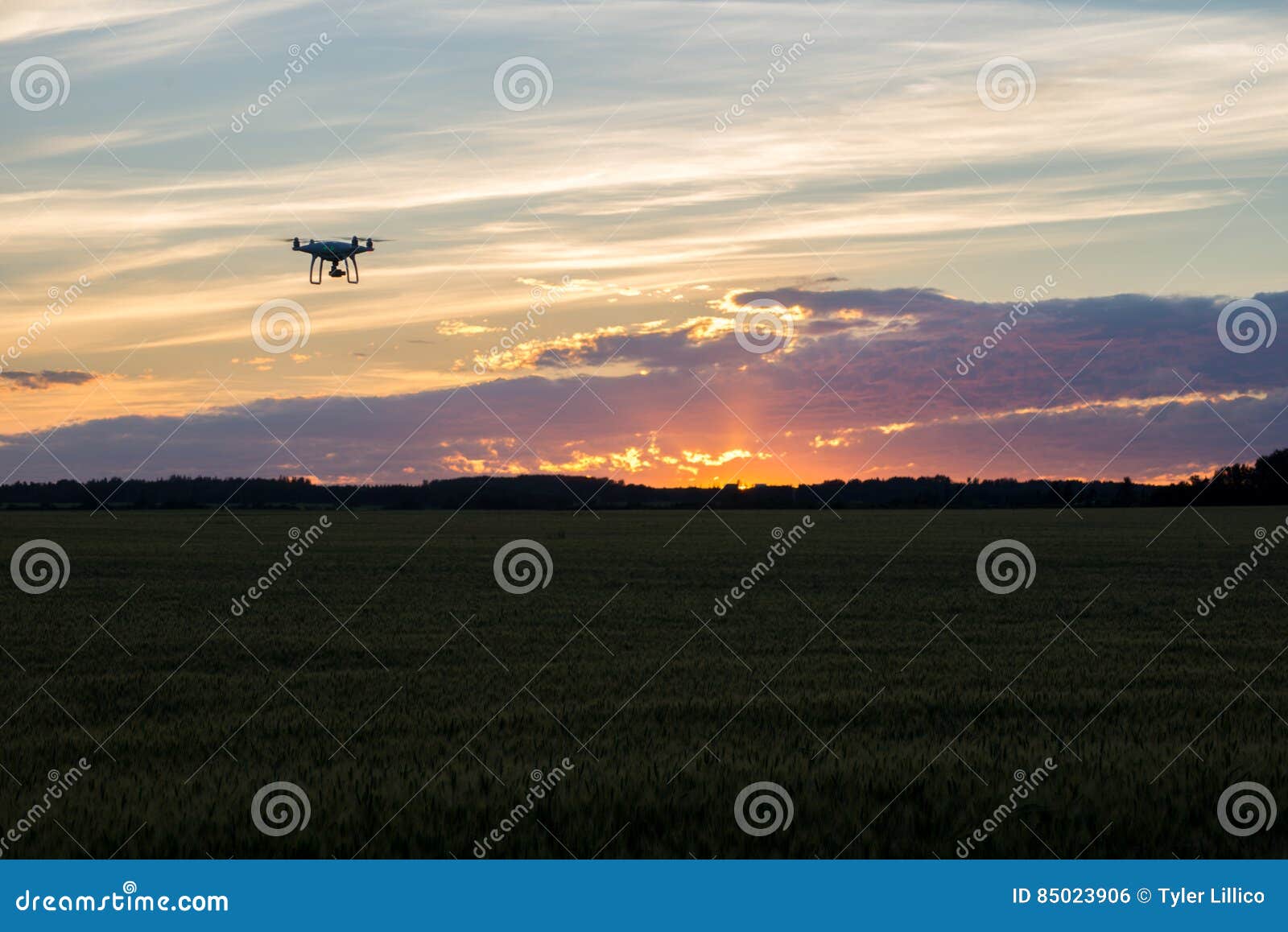 Drone Silhouetted Against Orange Sunset Stock Photo - Image of field ...
