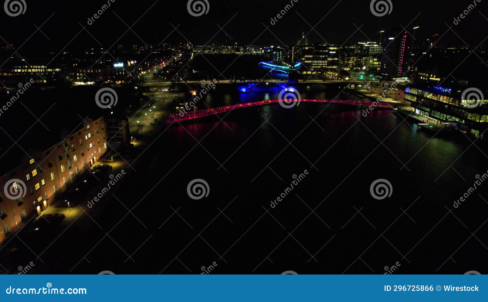 Drone View Over a River with Red Lighted Bridge and Illuminated ...