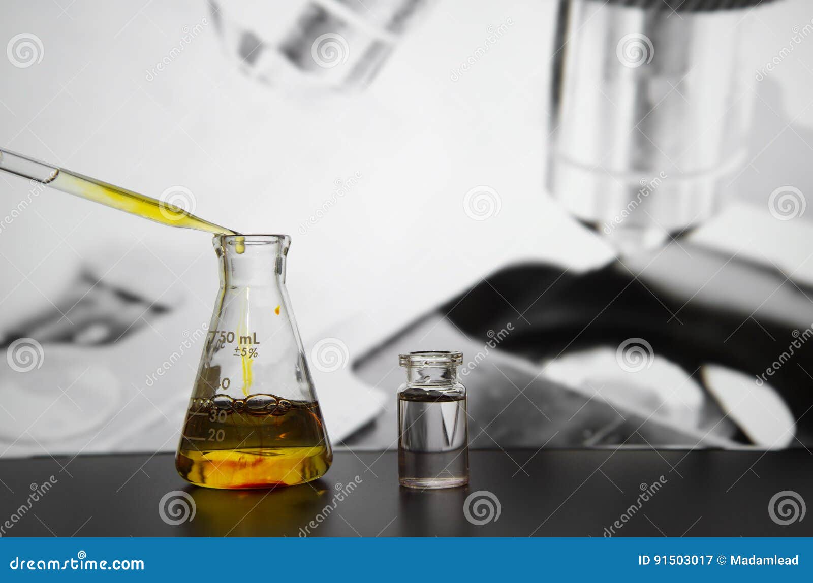 Drop of Yellow Solution in To Science Flask with Microscope Stock Image ...