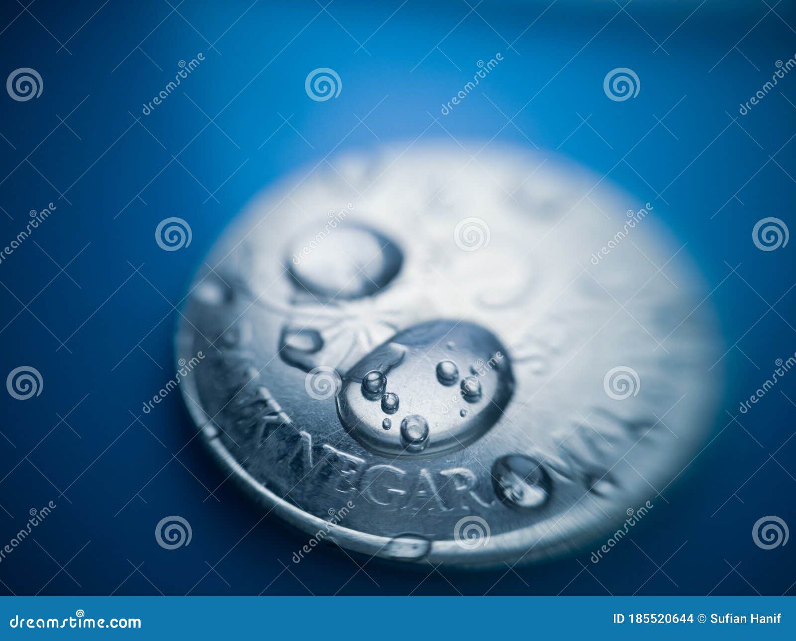 Droplets of Water Bubble on Top of Silver Coin with Blue Background ...