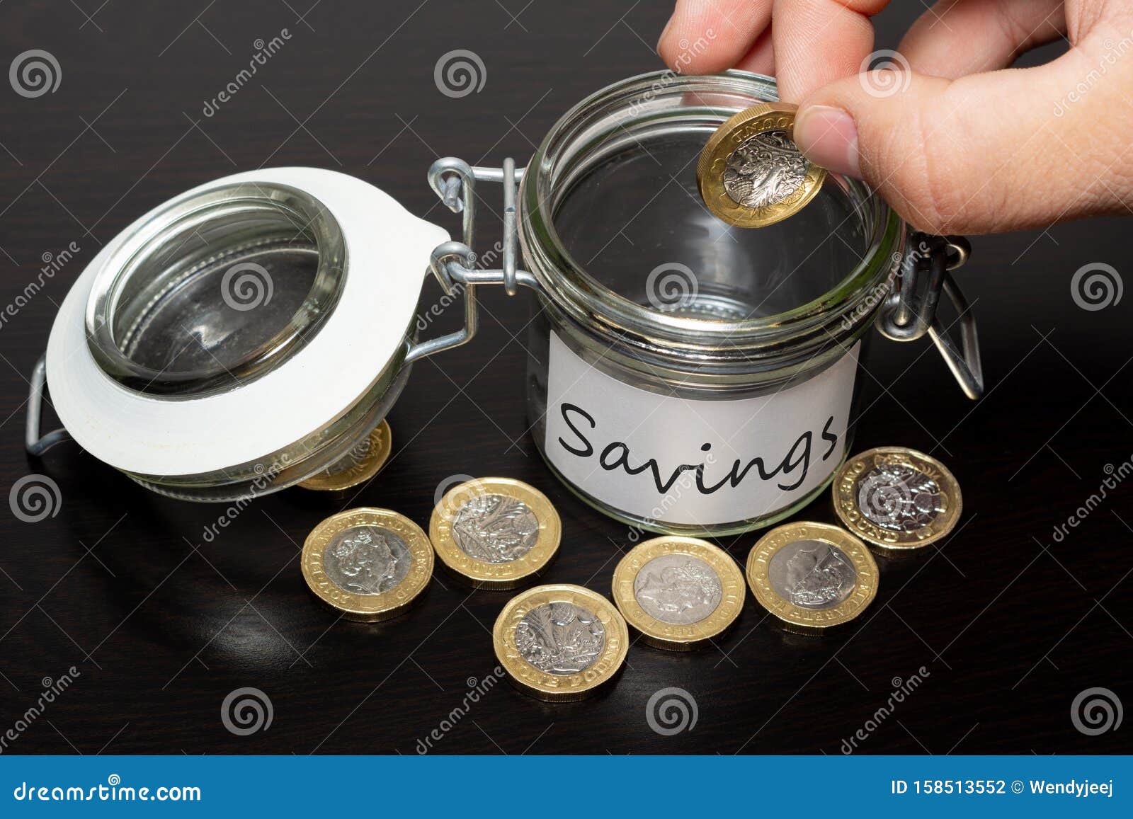 Dropping One Pound Coin into Jar for Savings Stock Photo - Image of ...