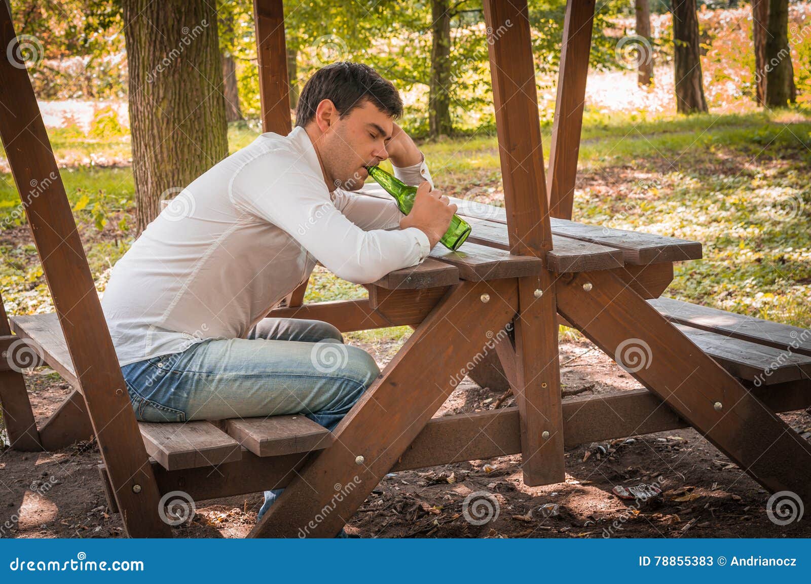 Drunk Man Sitting on a Bench and Holding a Beer Bottle Stock Image ...