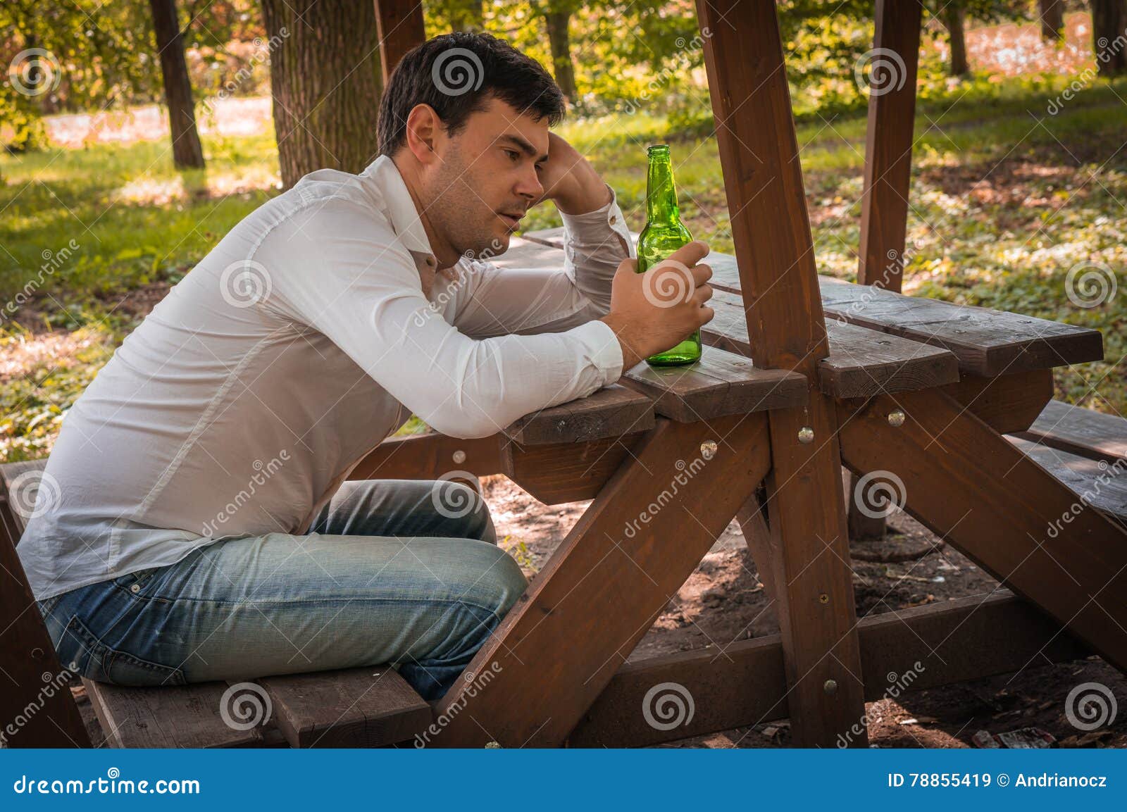 Drunk Man Sitting on a Bench and Holding a Beer Bottle Stock Image ...