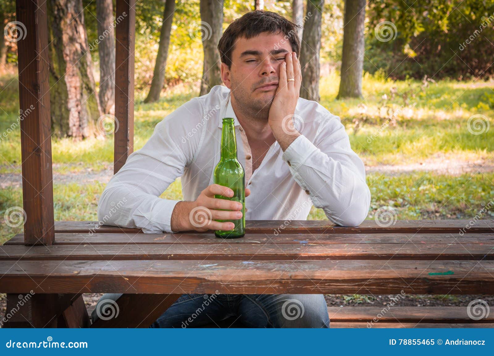Drunk Man Sitting on a Bench and Holding a Beer Bottle Stock Image ...